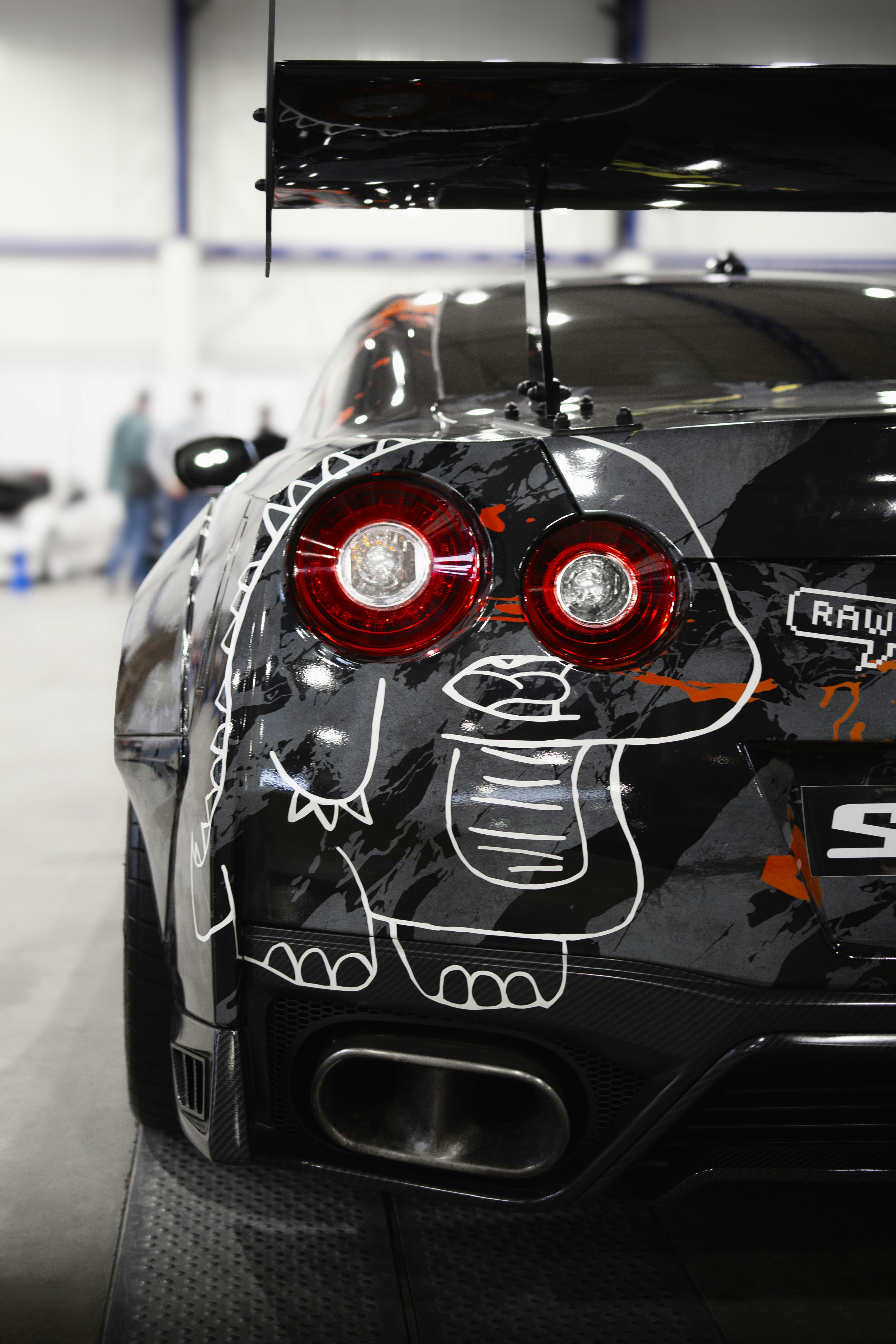 Rear View of a Graphic Racecar with White Line Art and Red Tail Lights