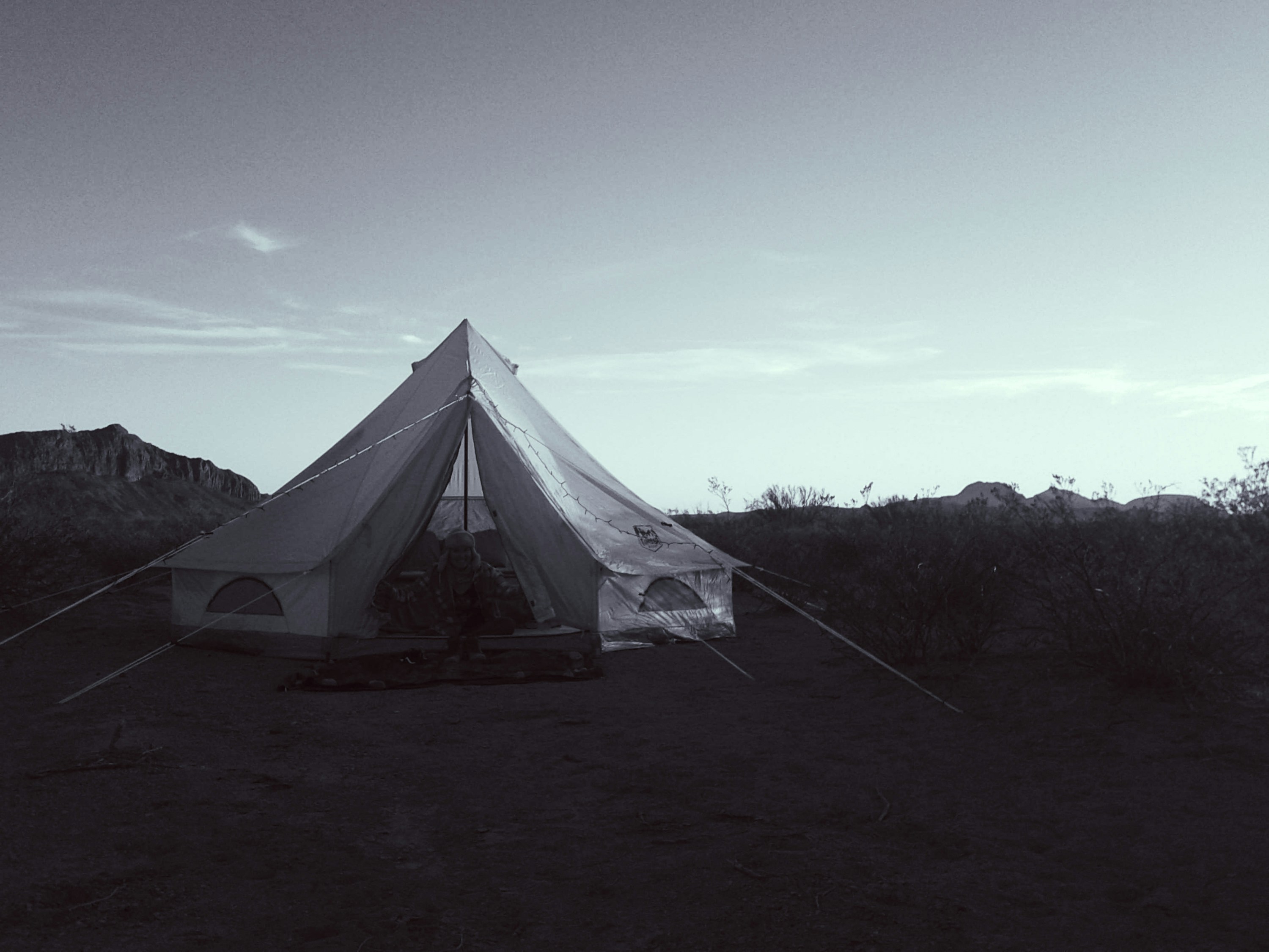 A bell tent set up in a dry, open landscape.