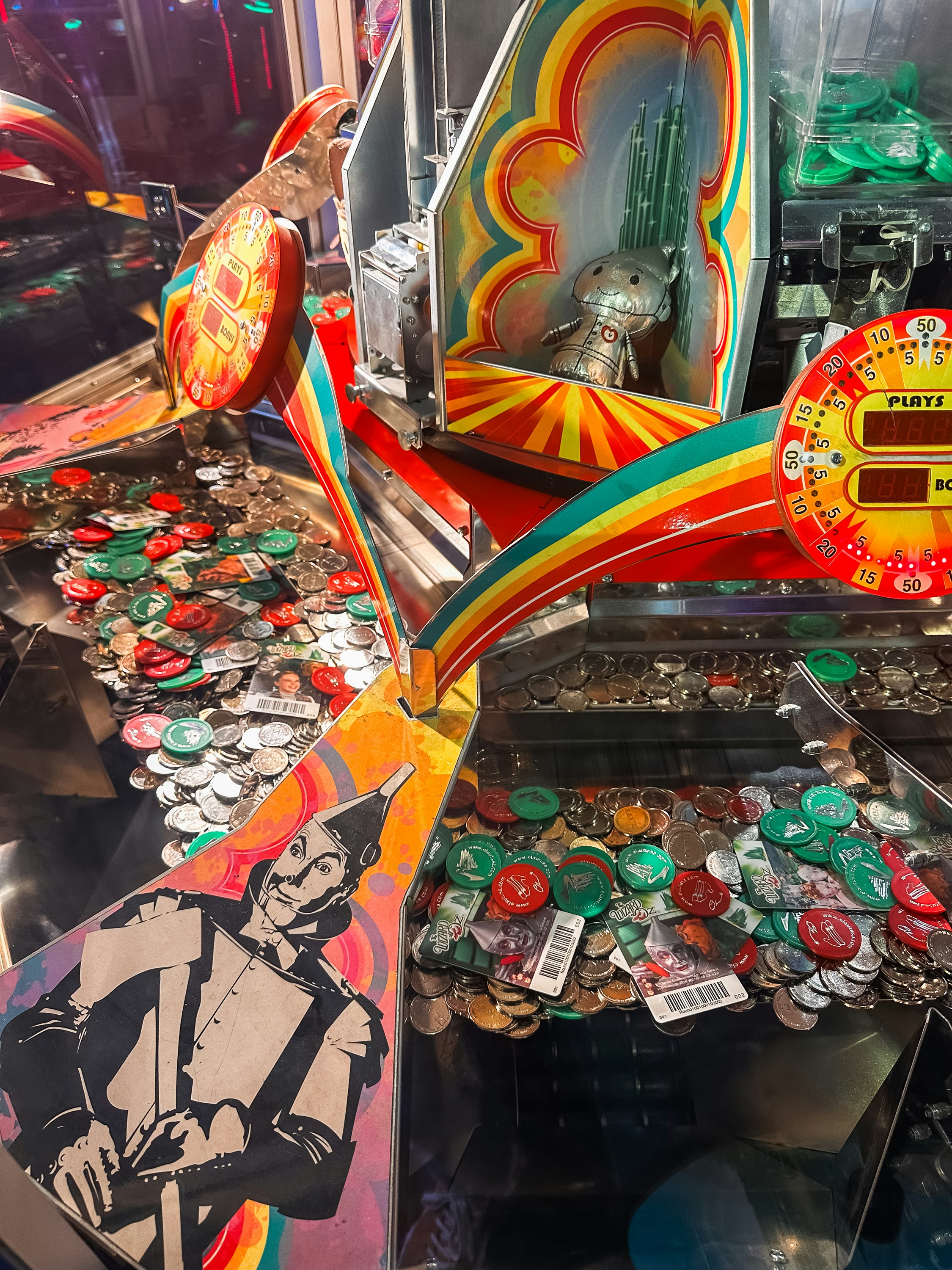 Colorful carnival prize machine with character art and arcade tokens