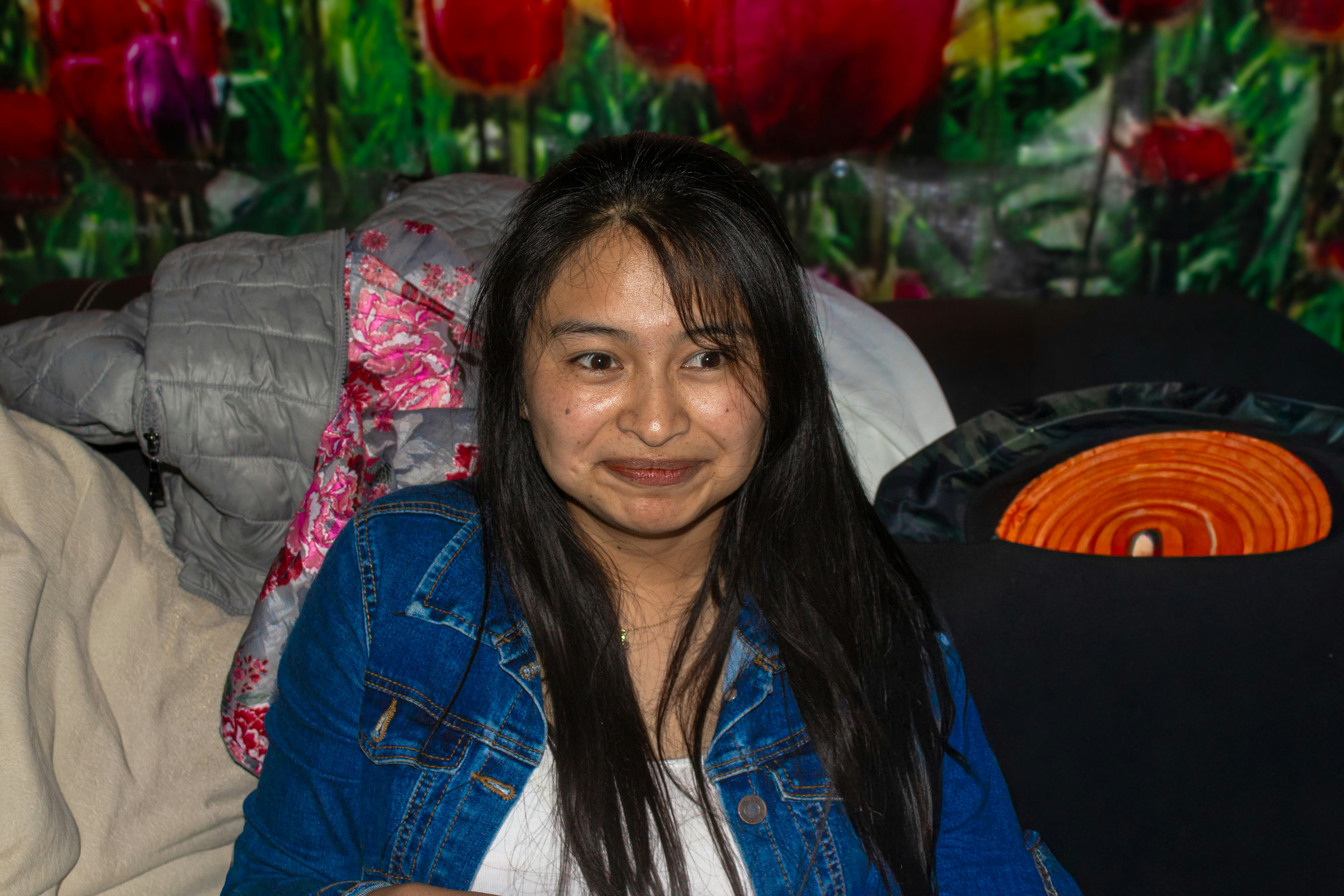 Smiling Moment on a Cozy Couch Against Floral Backdrop