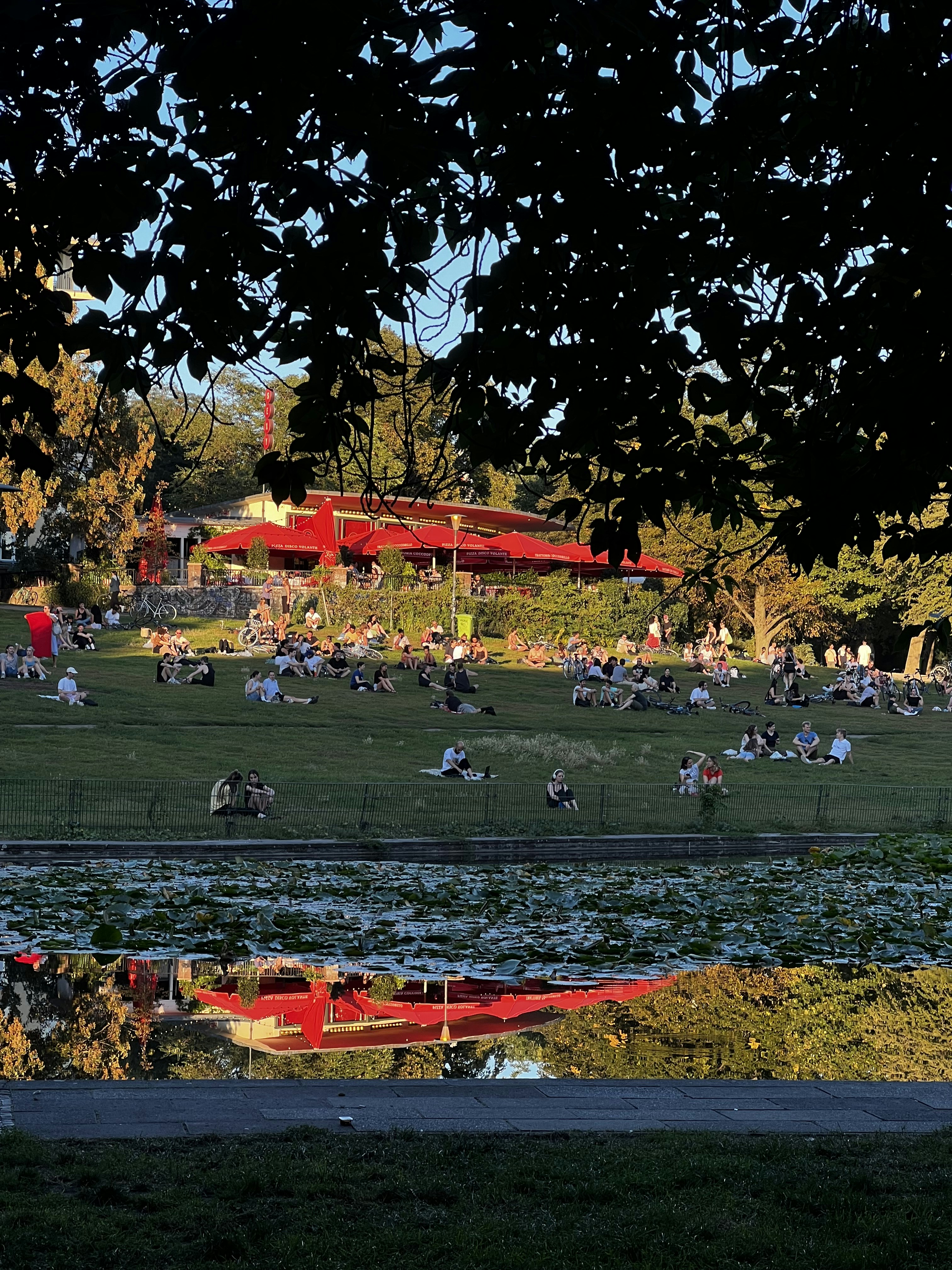 Red Canopies by the Riverside Lawn at Dusk