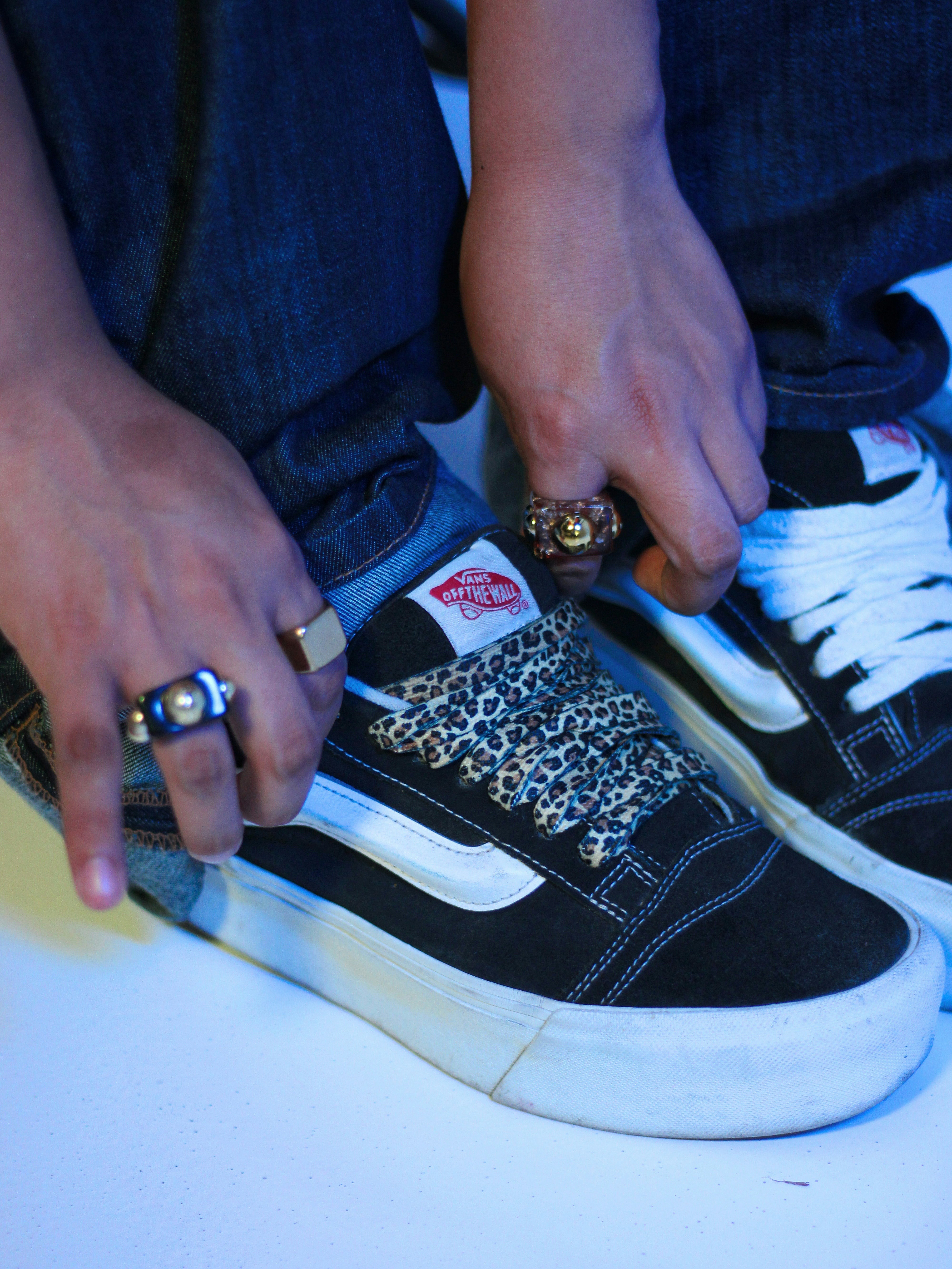 Leopard print lace and sneaker detail under fingertips
