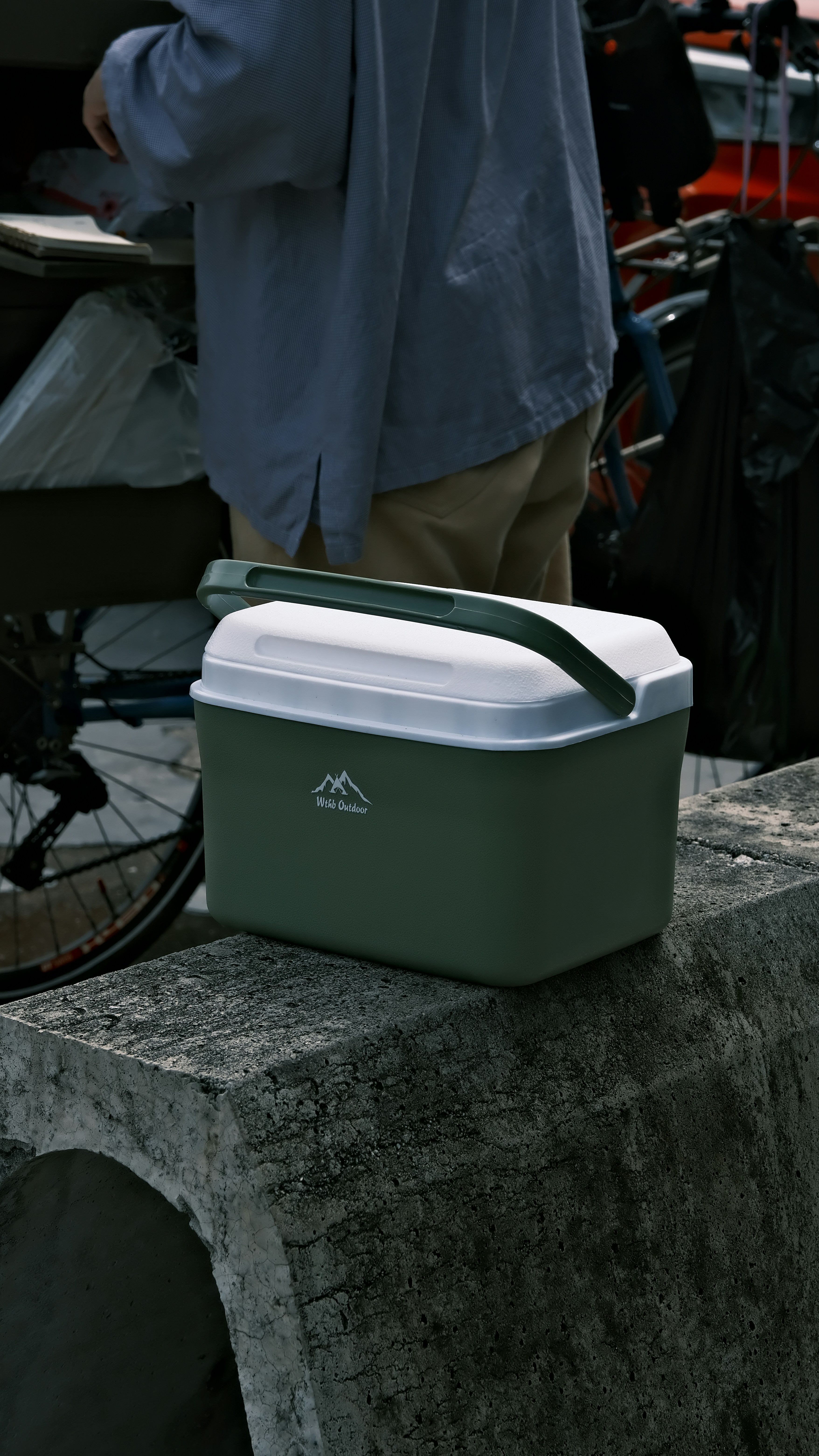 Green and White Cooler on a Concrete Barrier in an Urban Scene