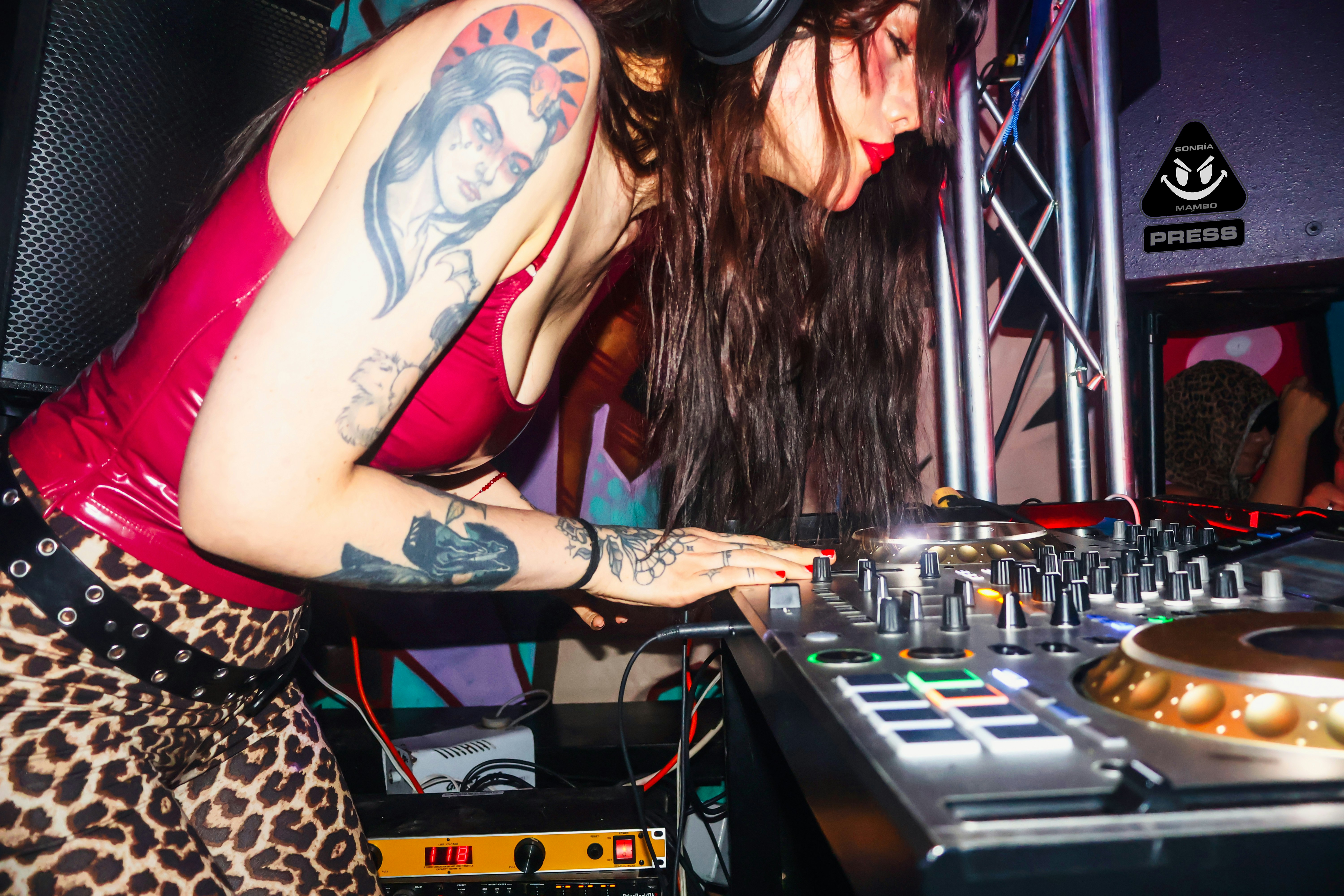 Tattooed DJ in Leopard Print, Nightclub Mixes Under Stage Lights