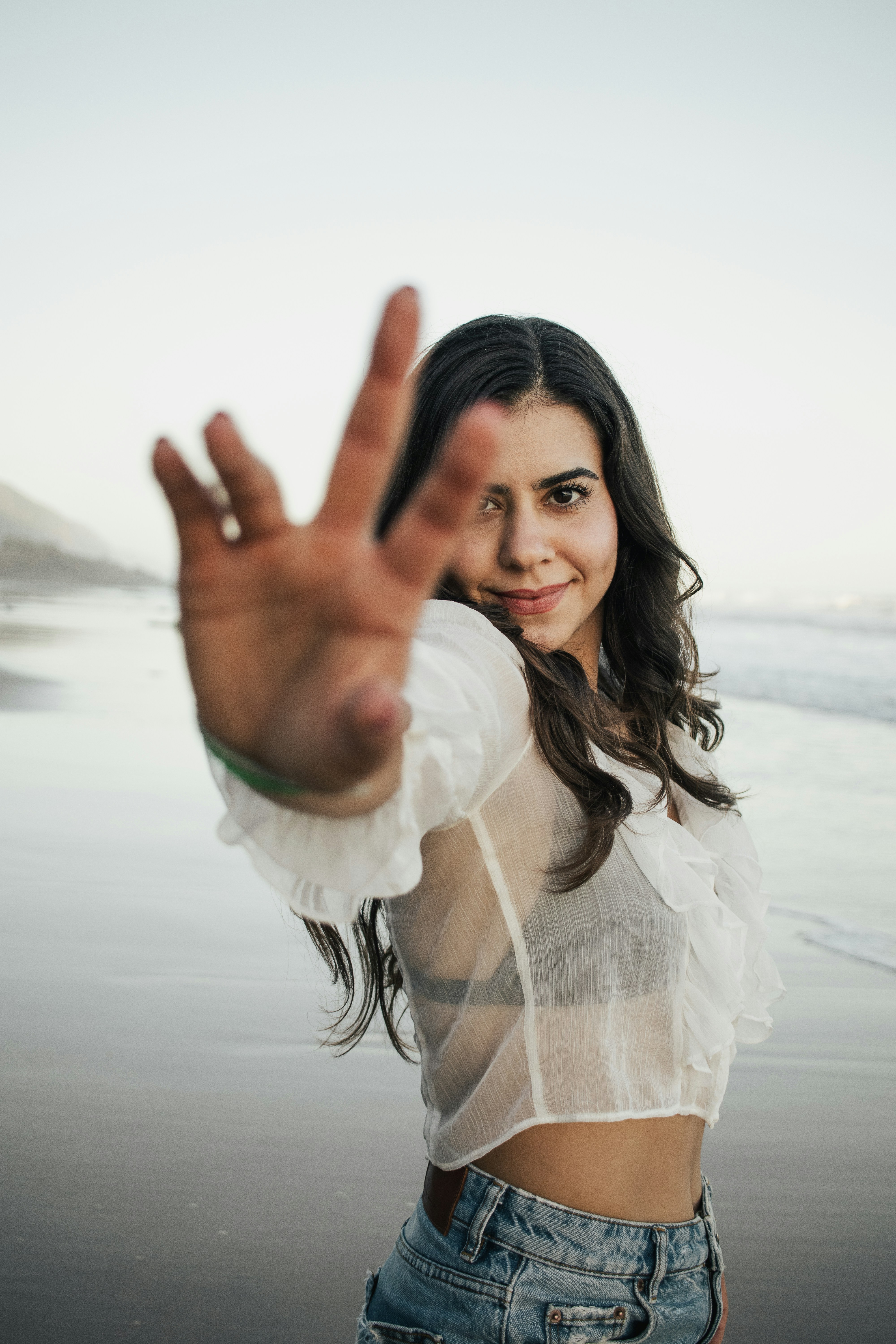Outstretched Hand, Quiet Sea: A Portrait at the Edge of the Shore