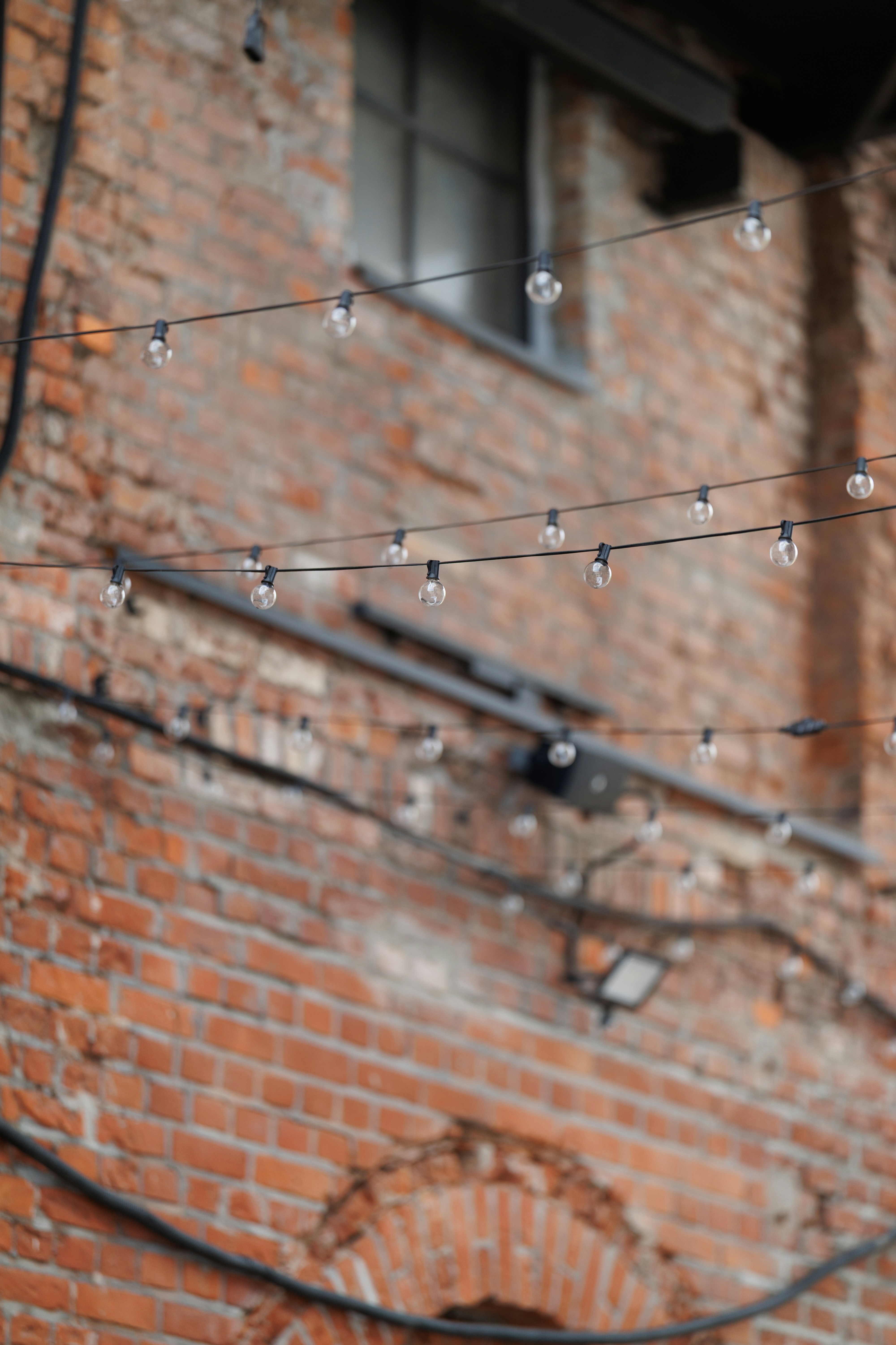 String of Evening Lights Across a Weathered Brick Wall