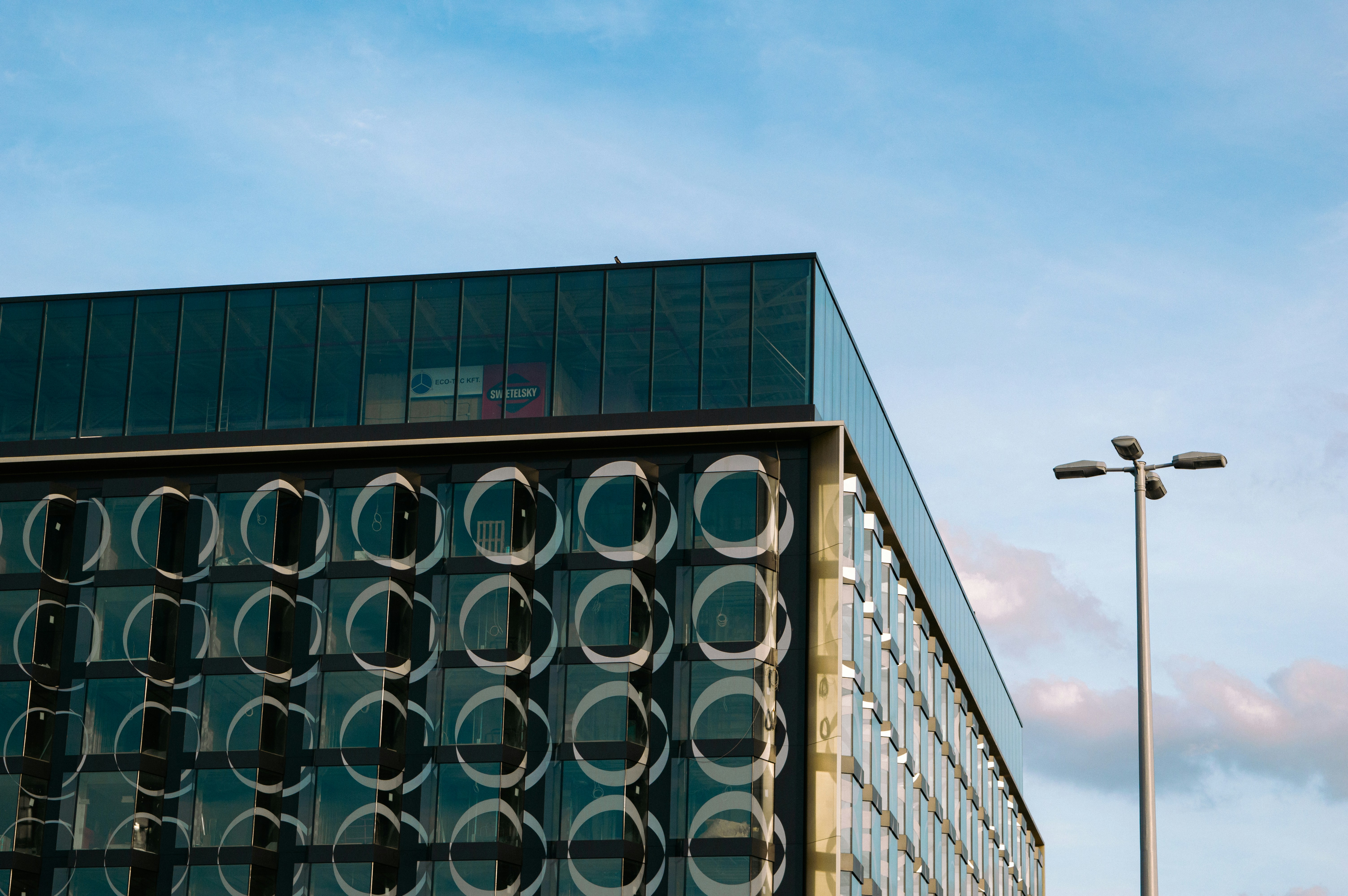 Geometric Glass and Circles: Corporate Facade Under Open Sky