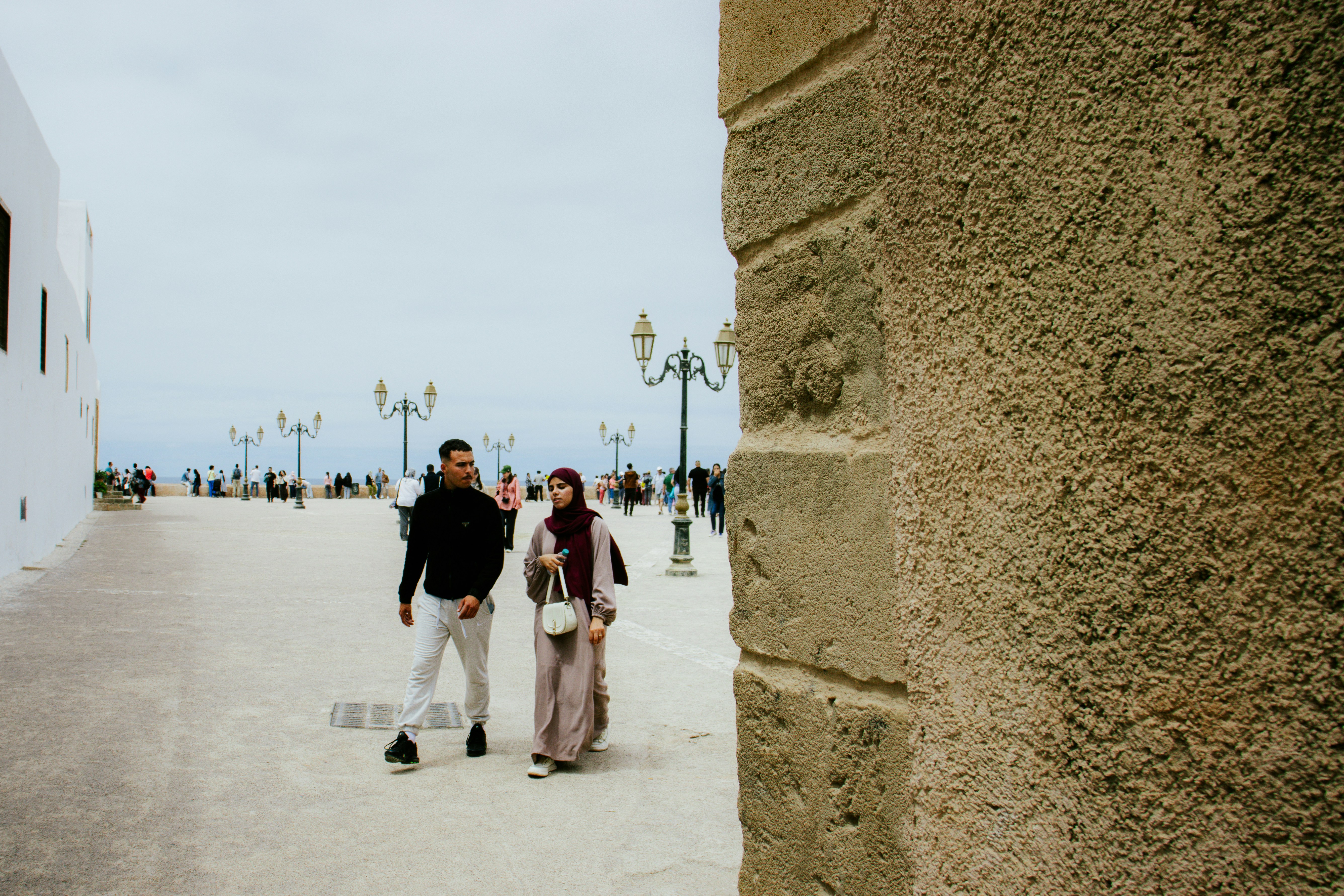 Lighthouse Boulevard: Passersby Along a Seaside Promenade