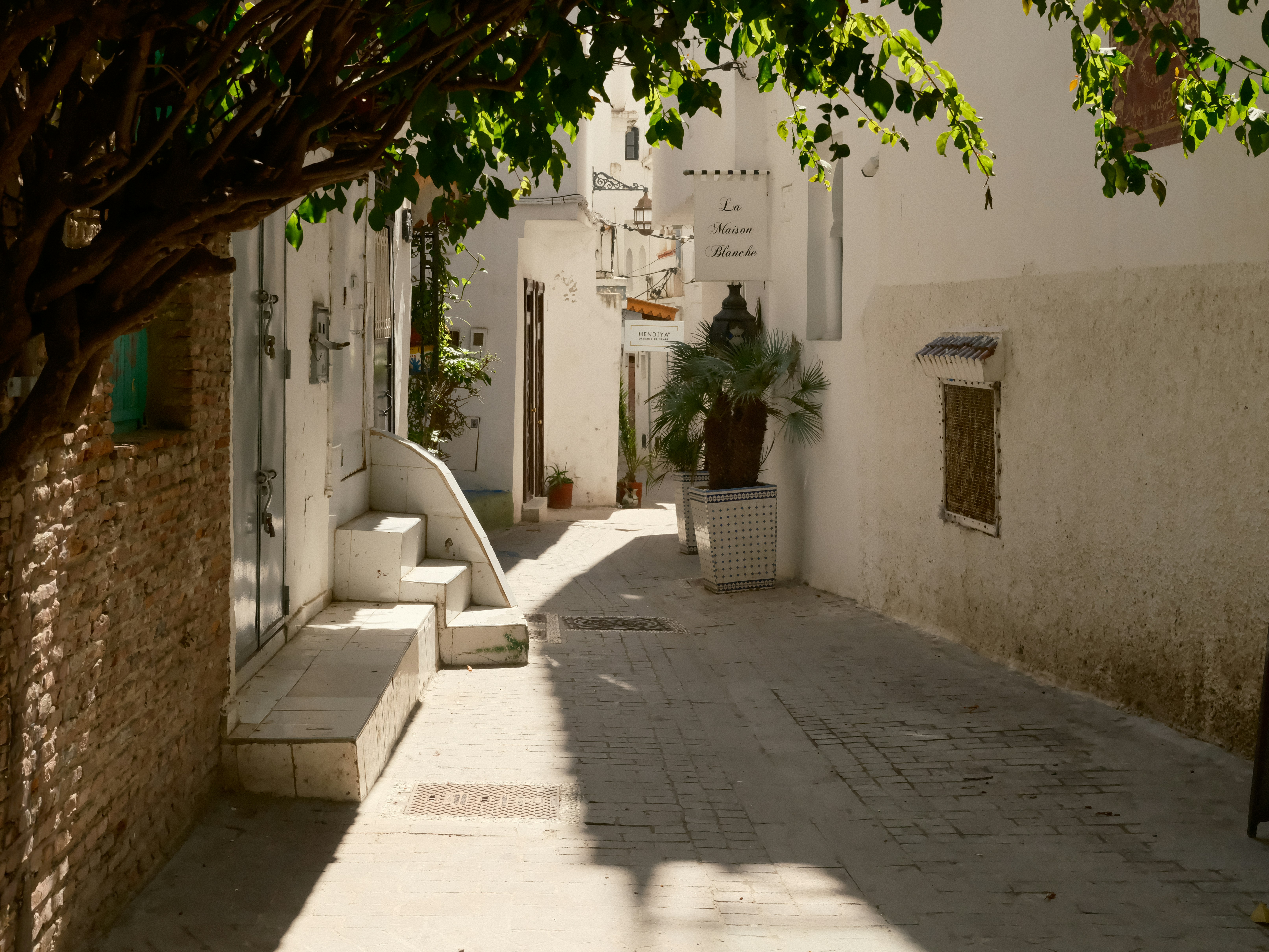 Sunlit Alleyway: Quiet Corridor of Whitewashed Walls and Shade