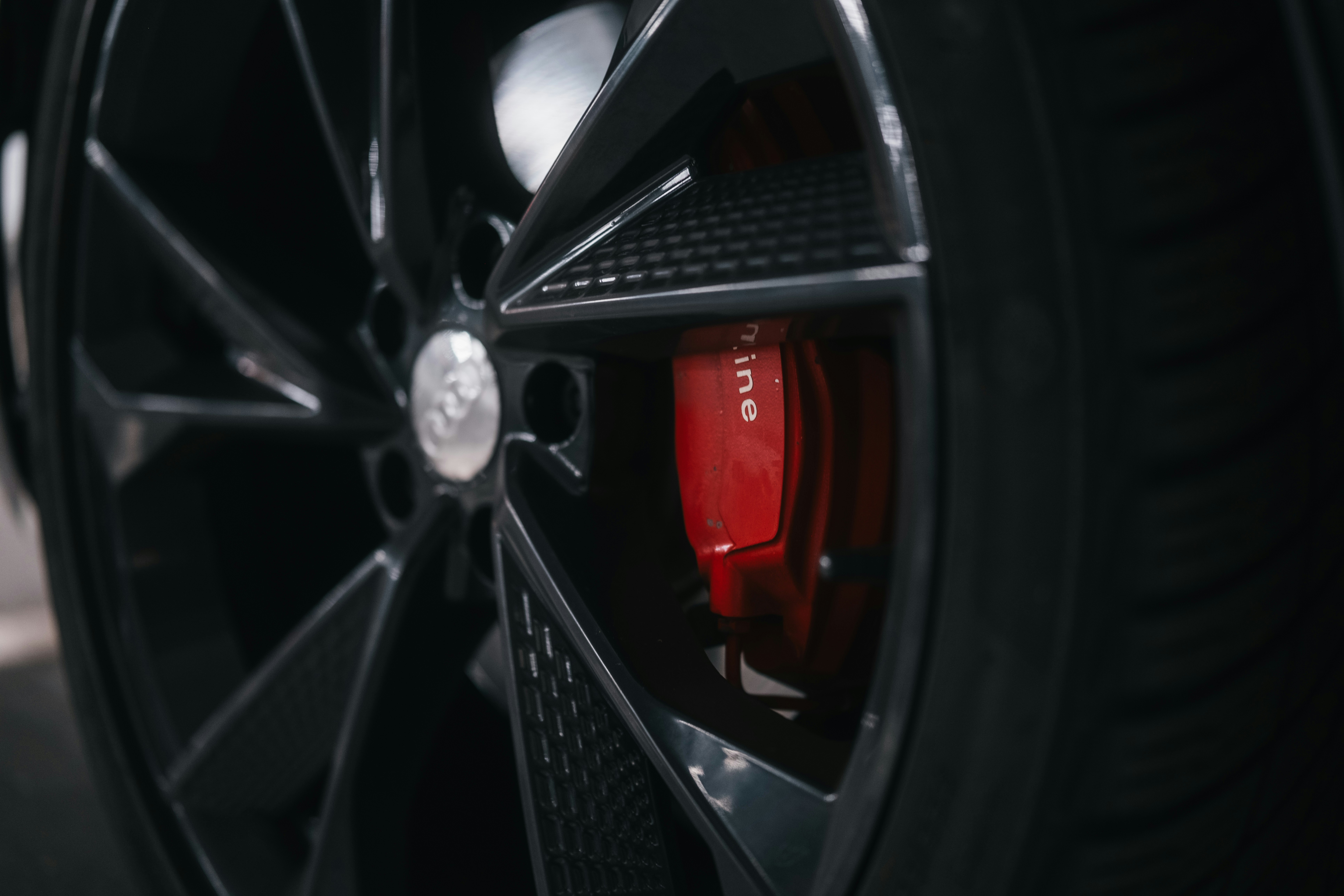 Red Brake Caliper Amid Black Alloy: A Precision Moment