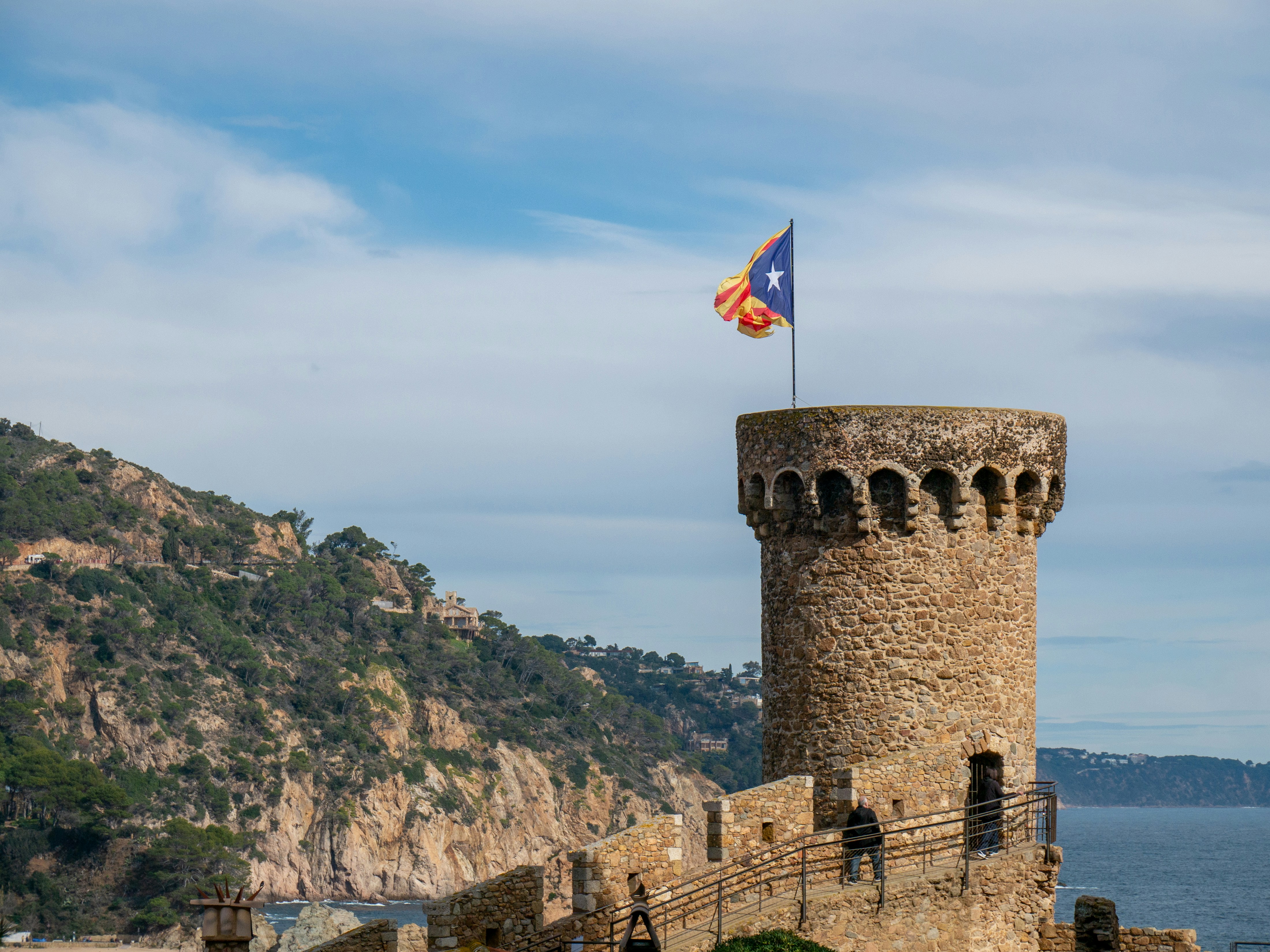 Flag over the coastal fortress: a lone observer atop the tower