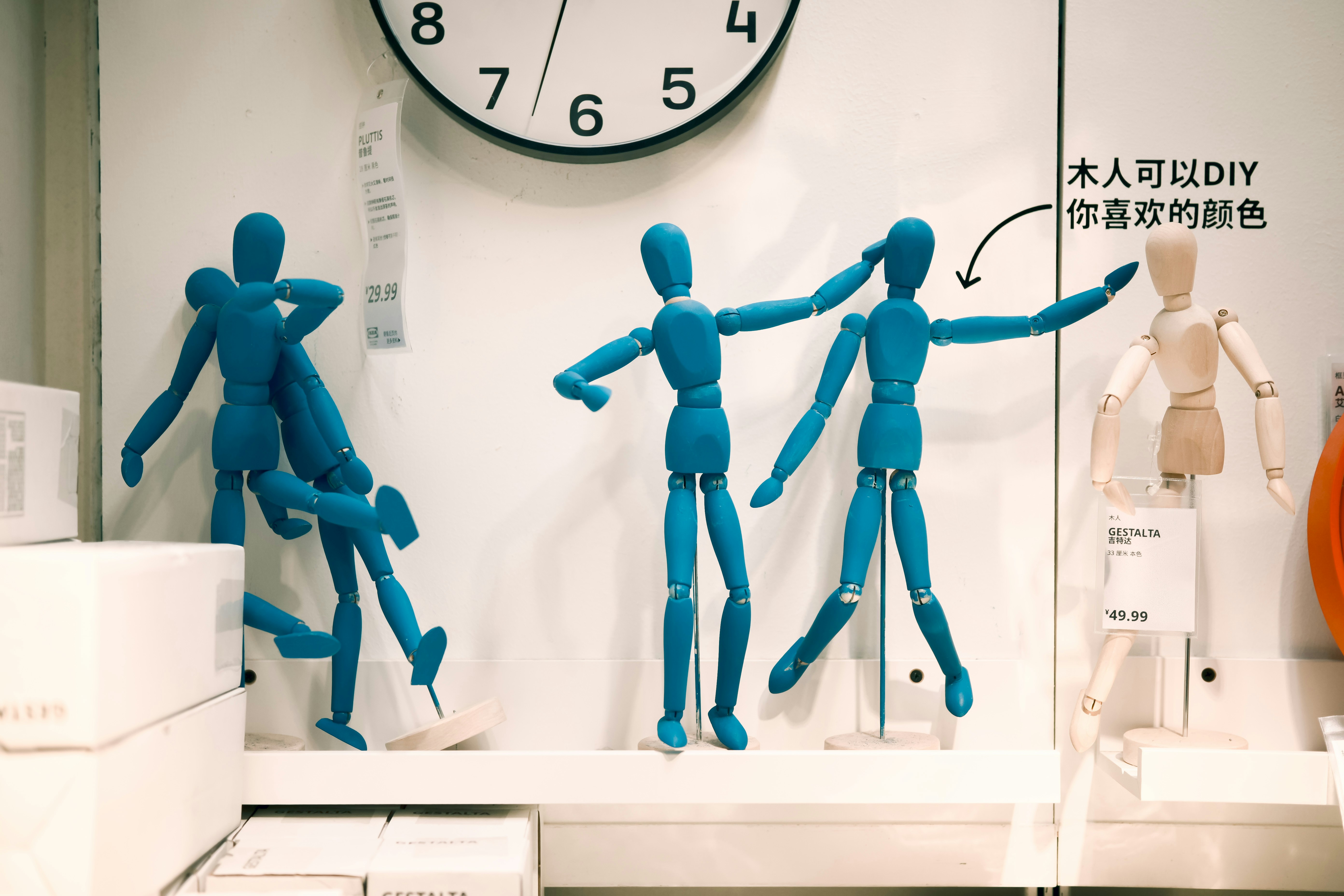 Blue poses in a minimalist mannequin showroom under a wall clock