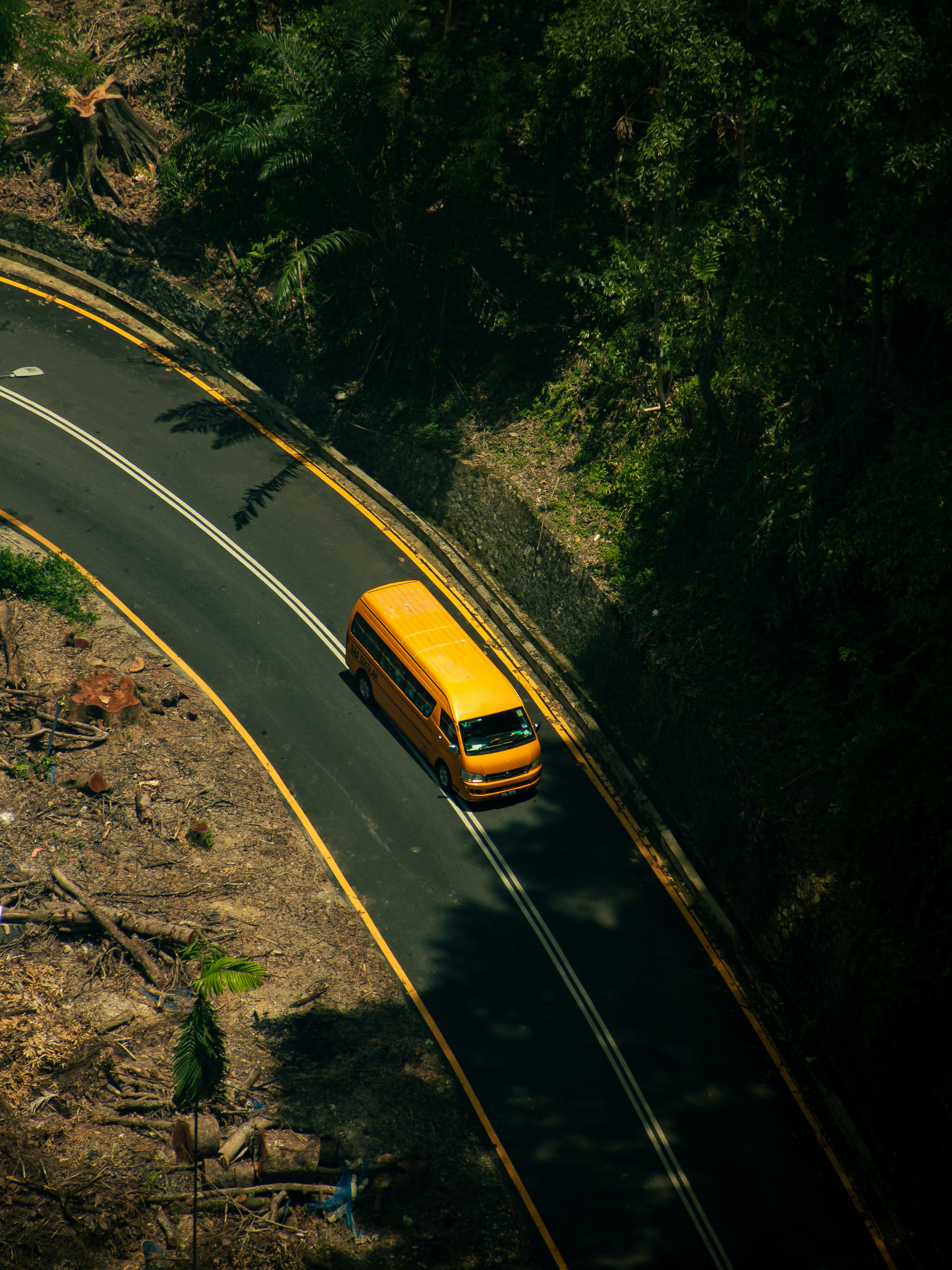 Curved Ascent: A Yellow Bus Traces a Winding Mountain Road