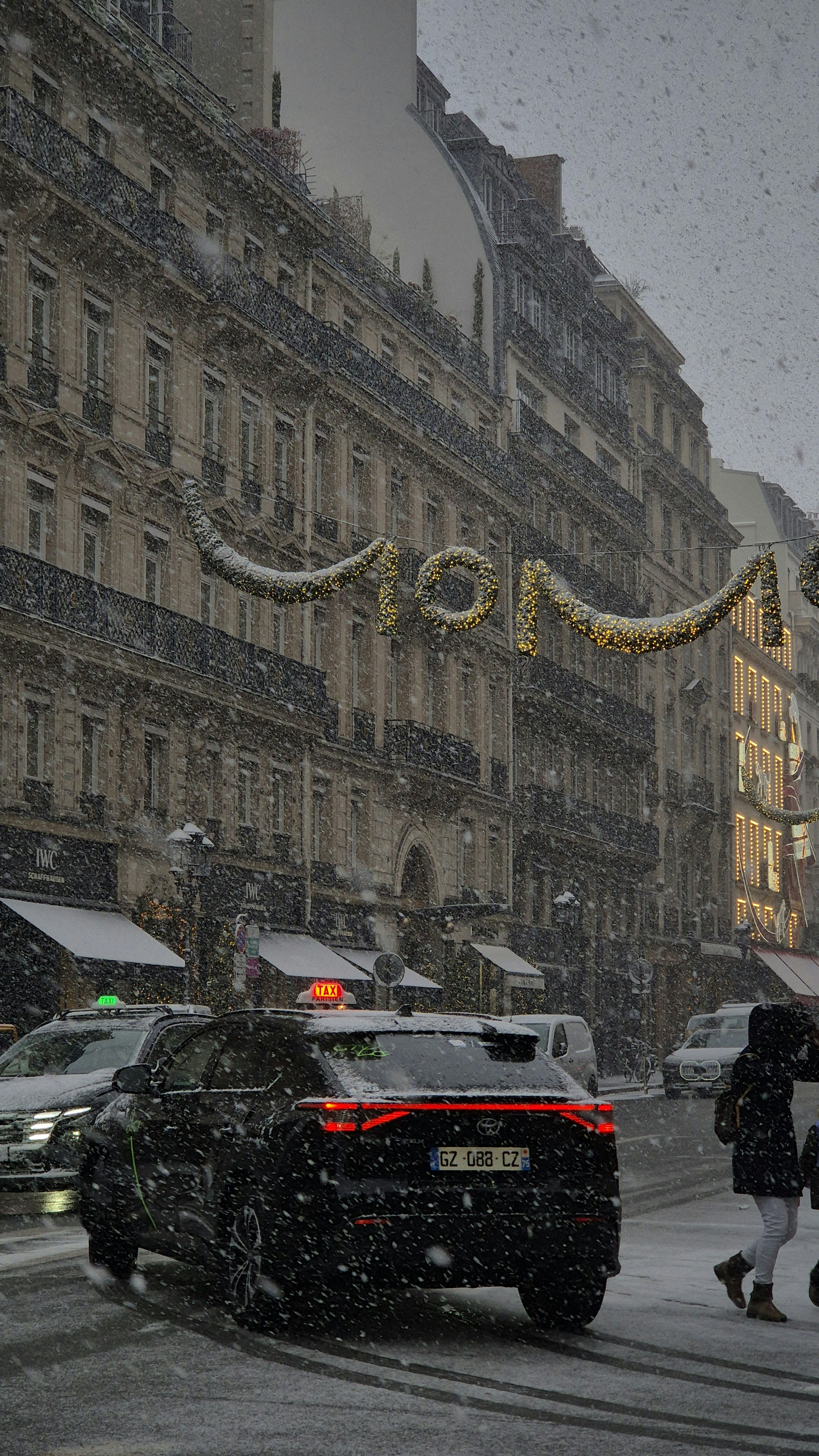 Snowfall on a City Street: Holiday Lights and Moving Traffic