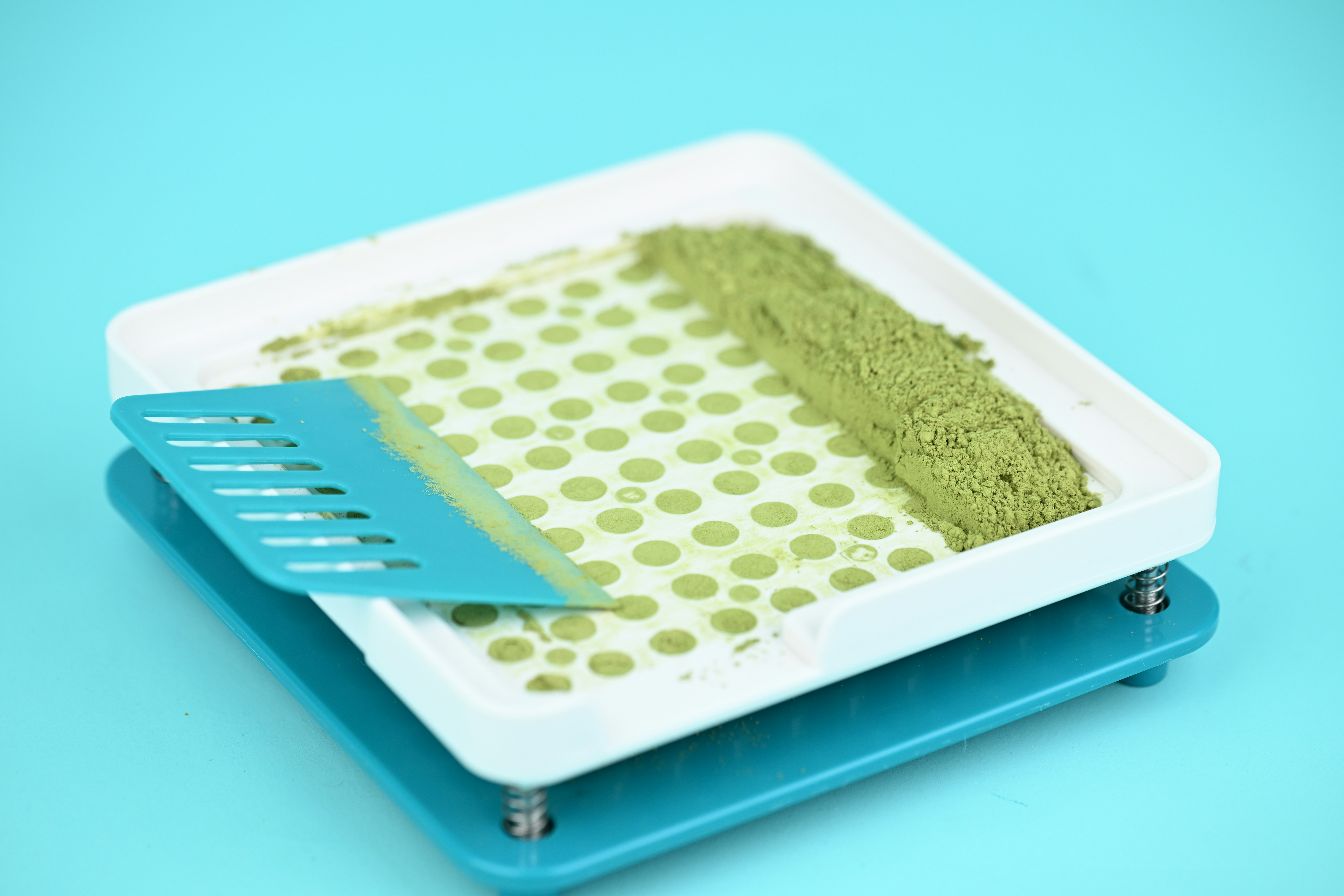 Blated® Cap & Press™ Core Series 100 hole capsule filling machine with herbal powder sitting on top waiting to be spread - Photo courtesy of https://blated.com - credit appreciated