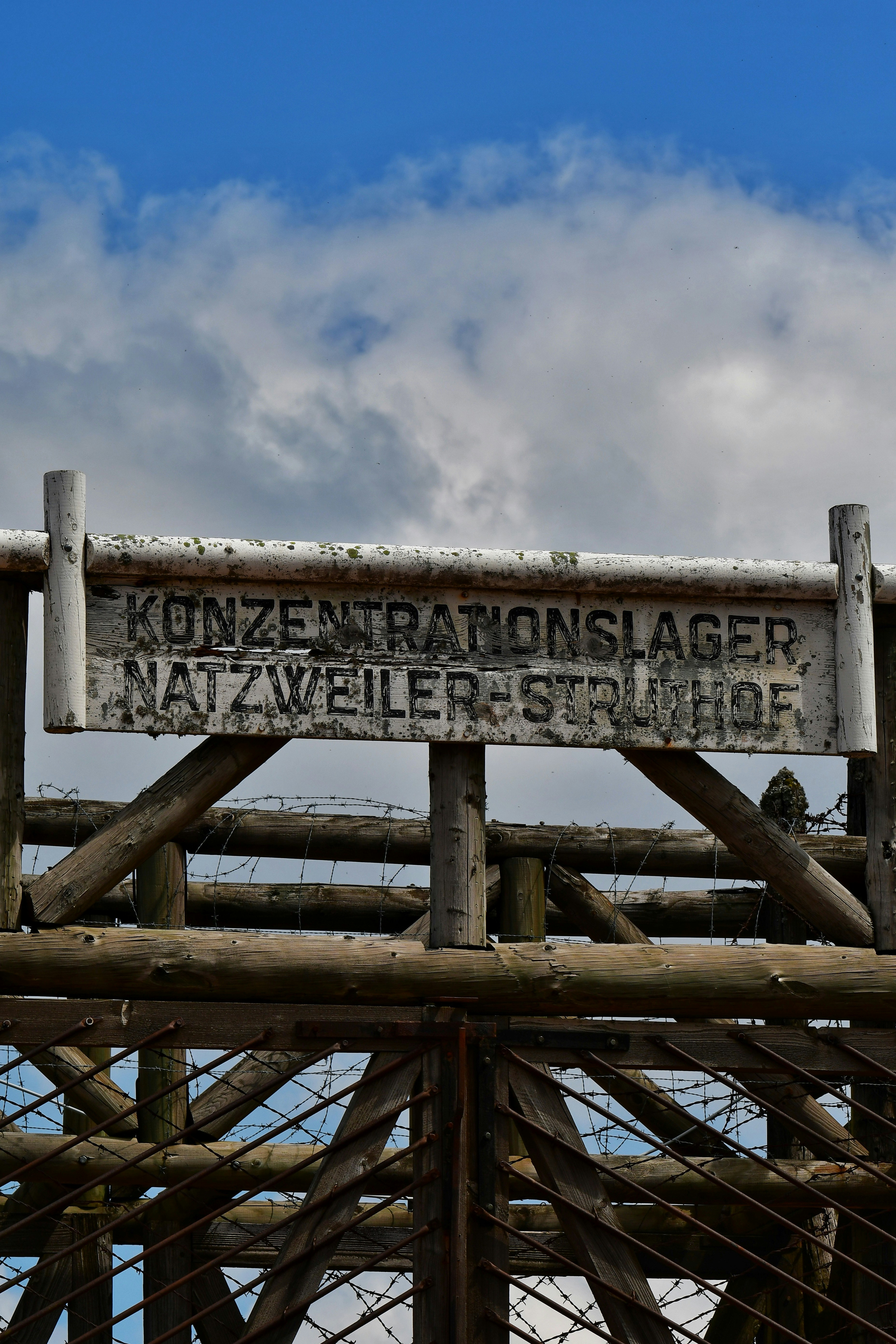 Weathered Border Sign Over a Wooden Fence