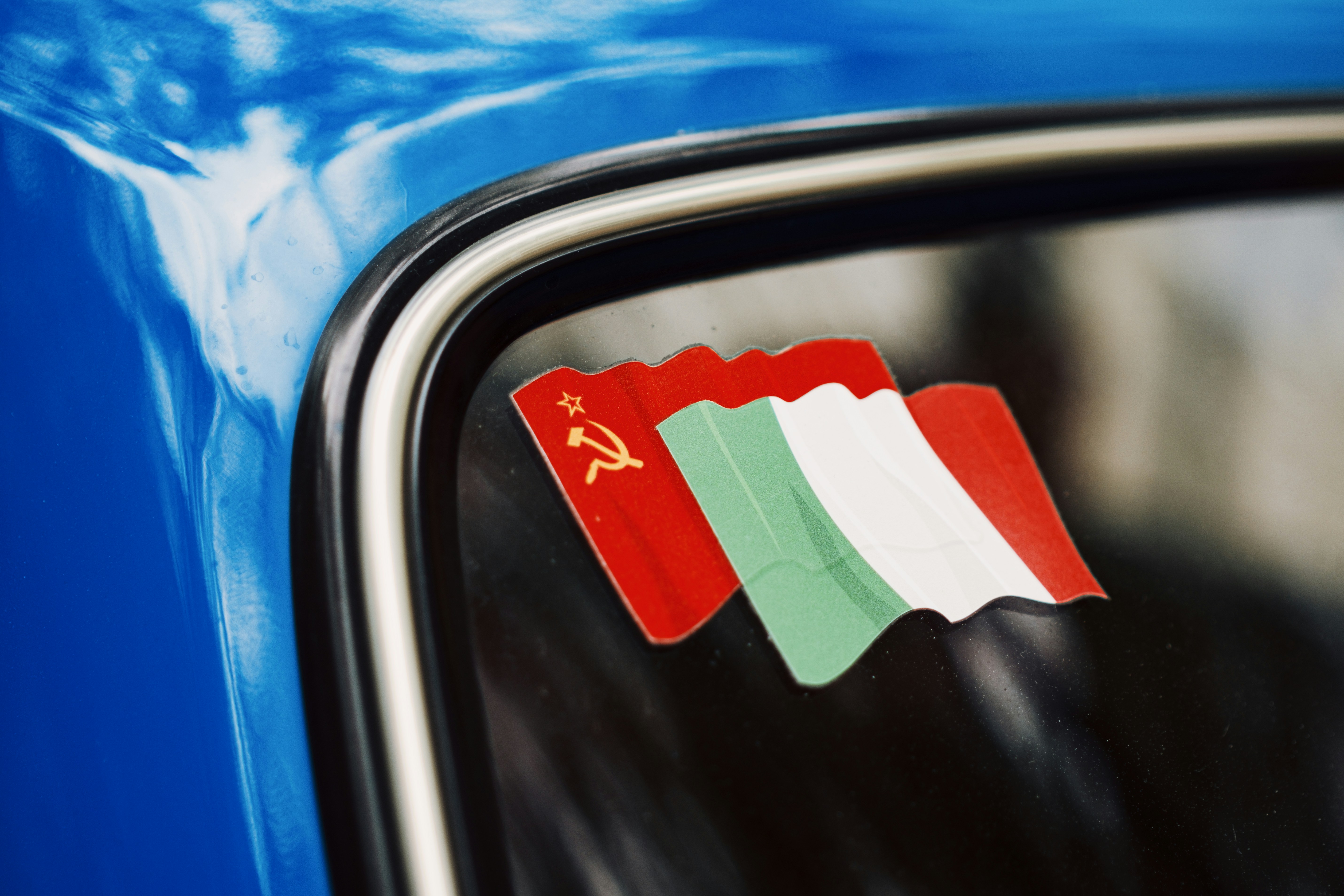 Streaks of Red, Green, and White: Soviet Union Flag Reflections in Blue Car Window