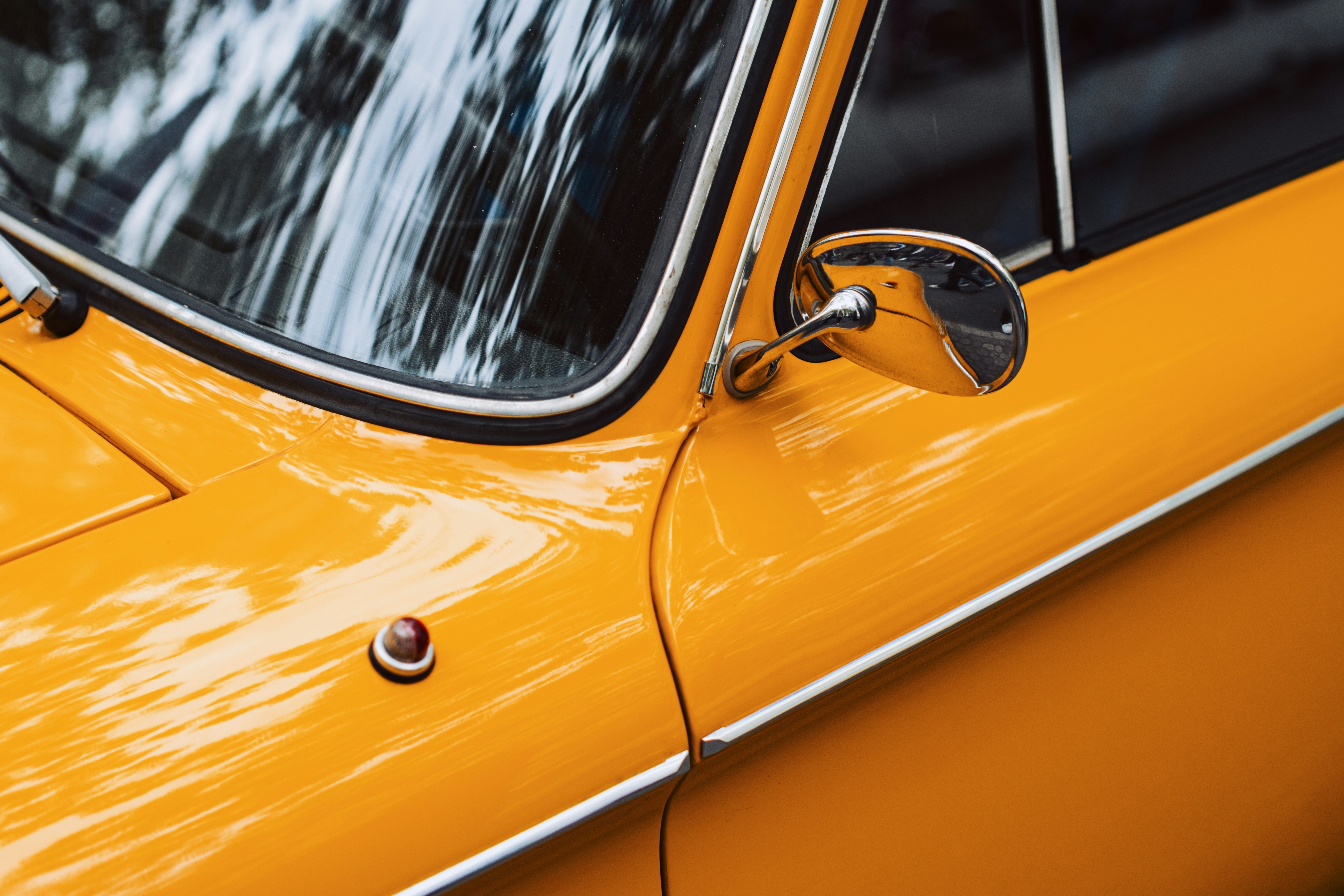 Chrome and Citrus: An Intimate Glimpse of a Classic Orange Car Door