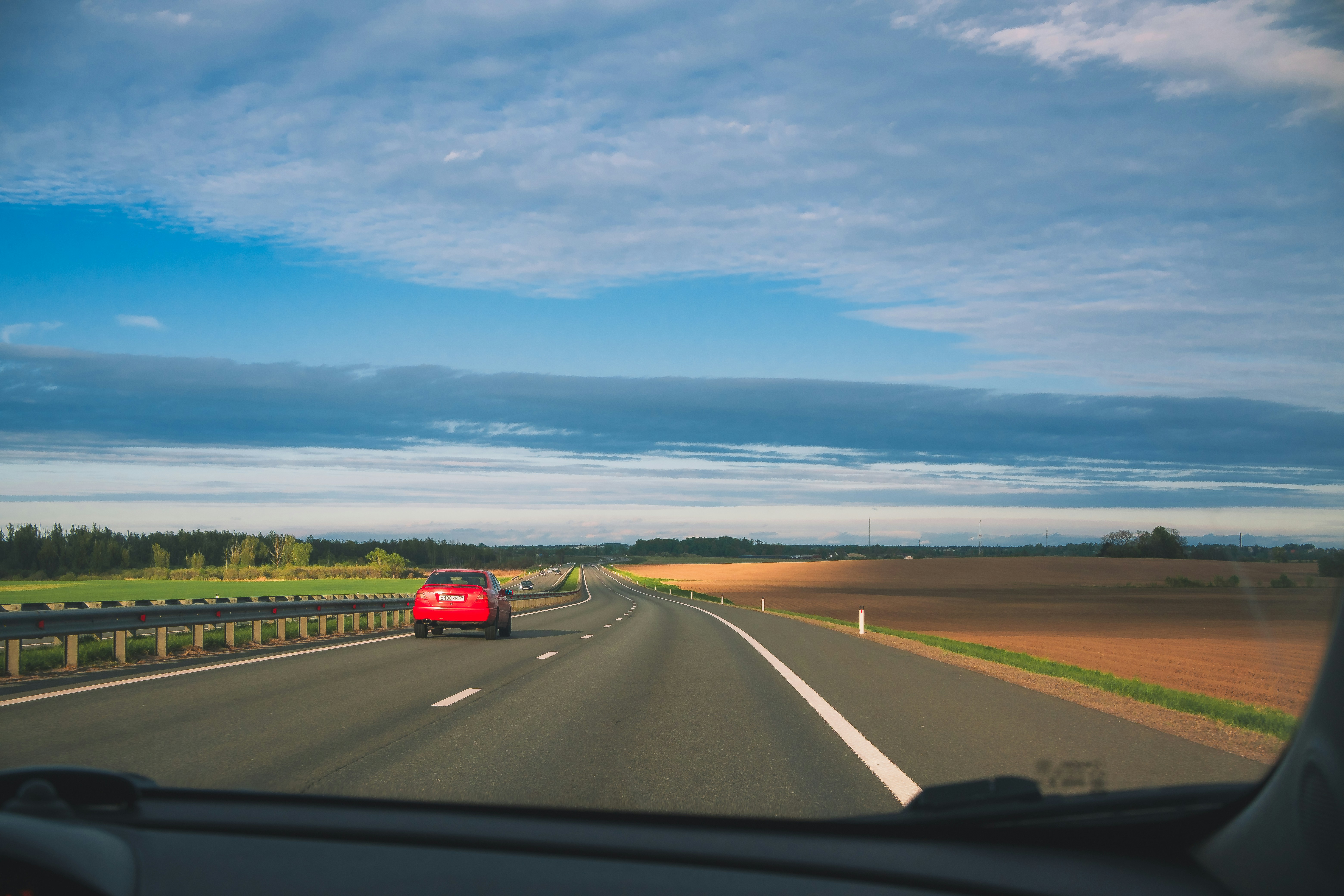 Horizon Road: Red Car Leading the Way
