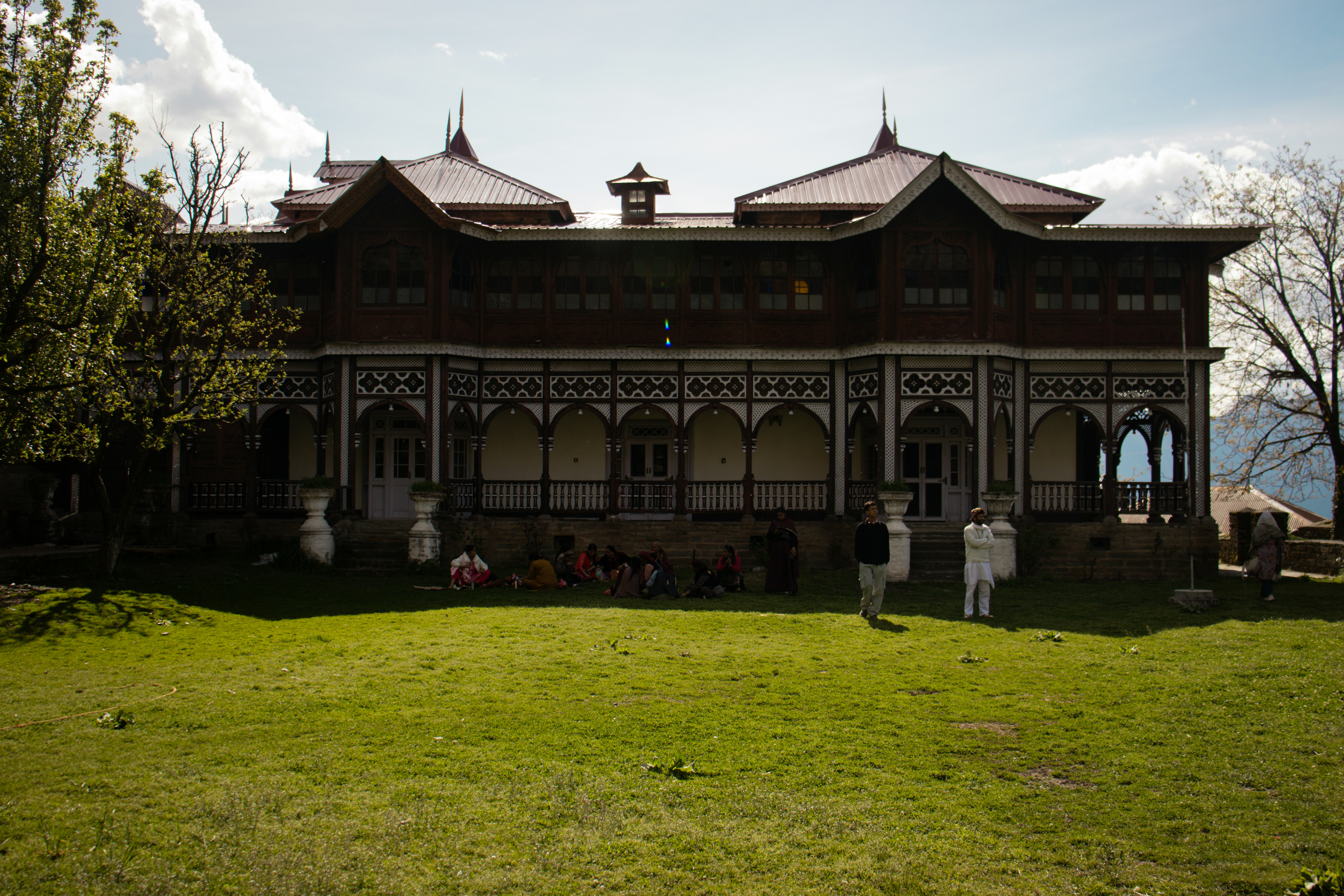 Ornate wooden building with a large green lawn