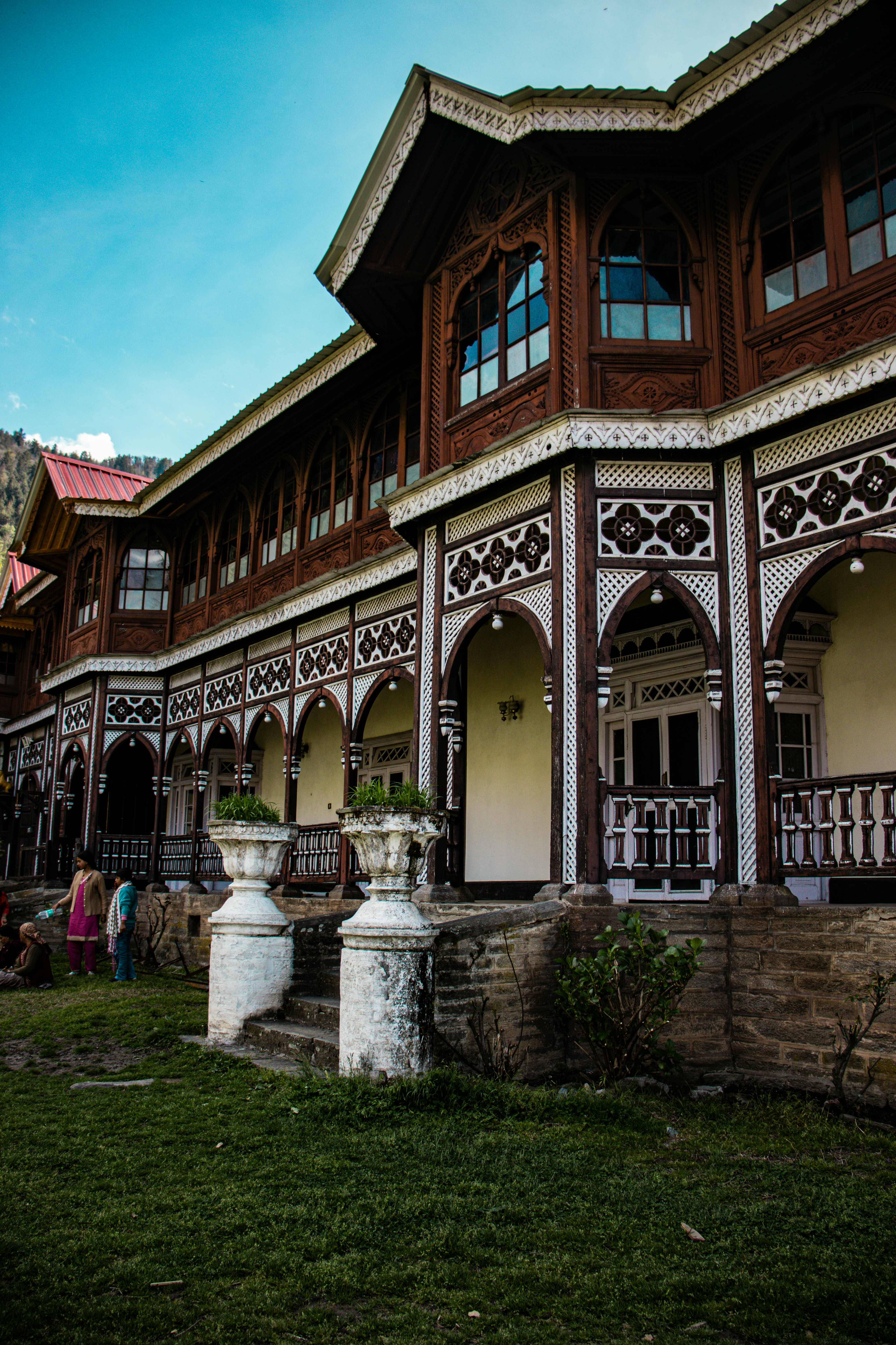 Ornate Veranda Chronicles: Carved Wood and Arcaded Facade