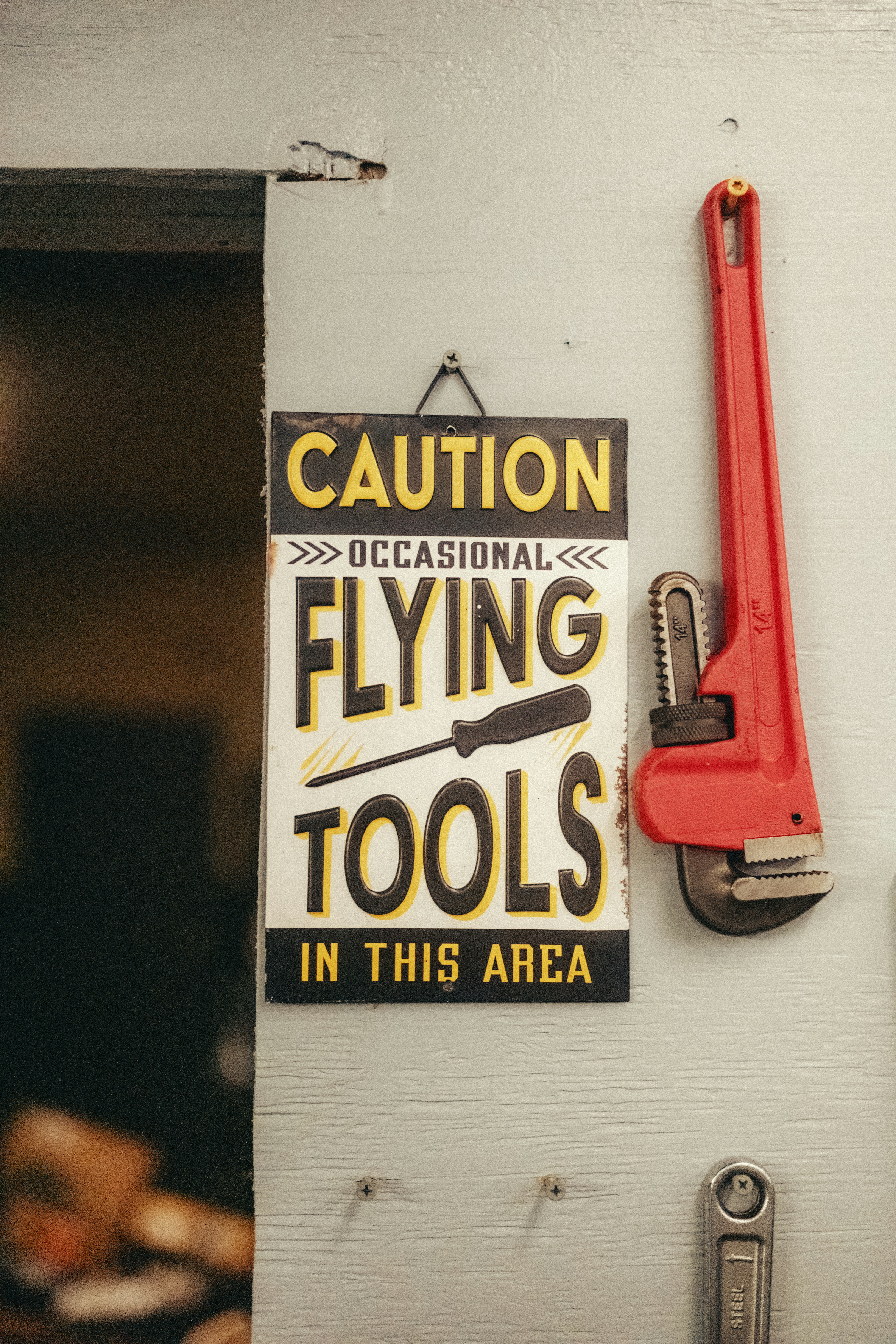 Tools of Caution: A Red Mallet and a Sign in a Quiet Workshop