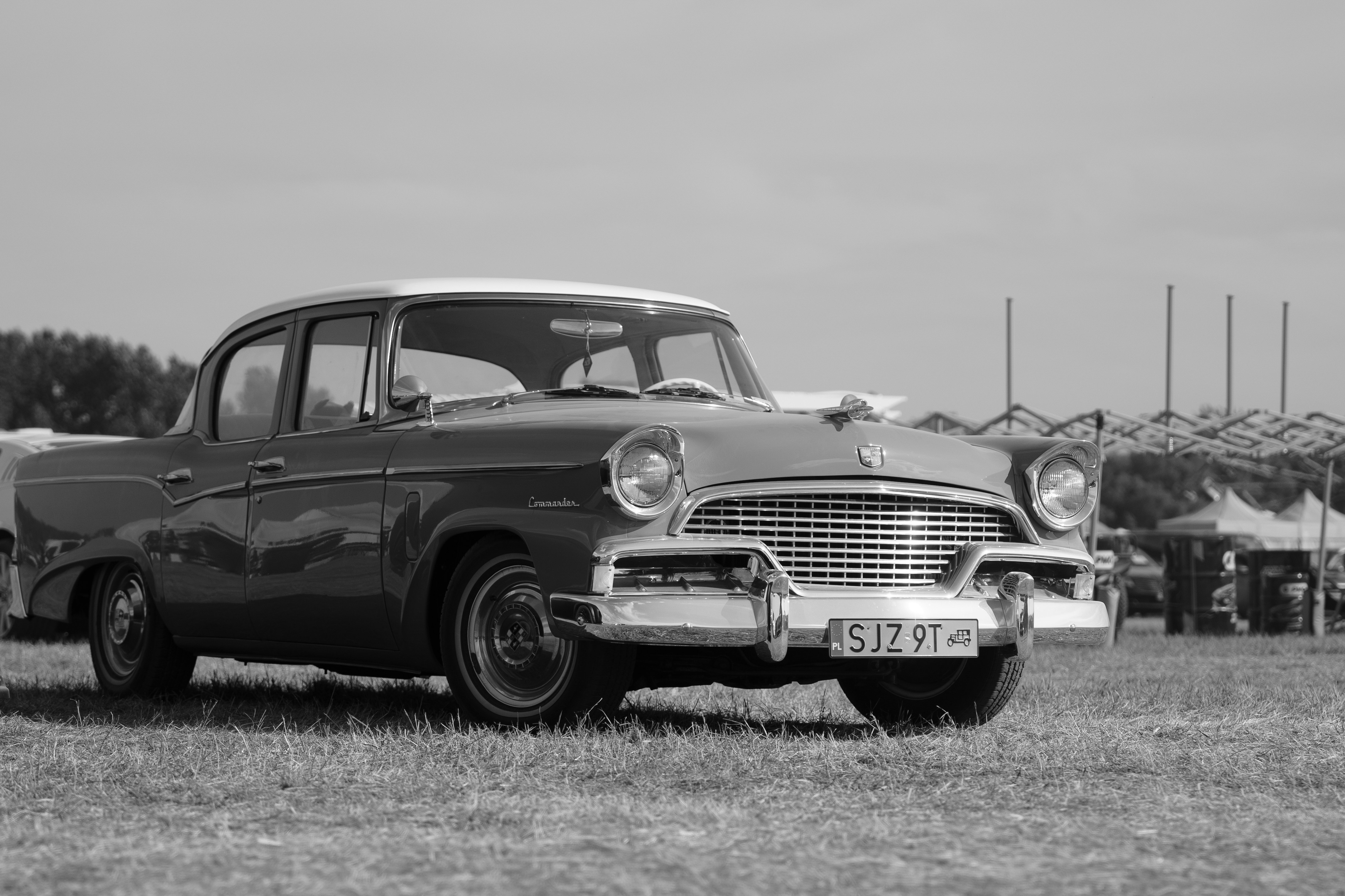 Chrome undercarriage and curves: a mid-century cruiser at a sunlit field