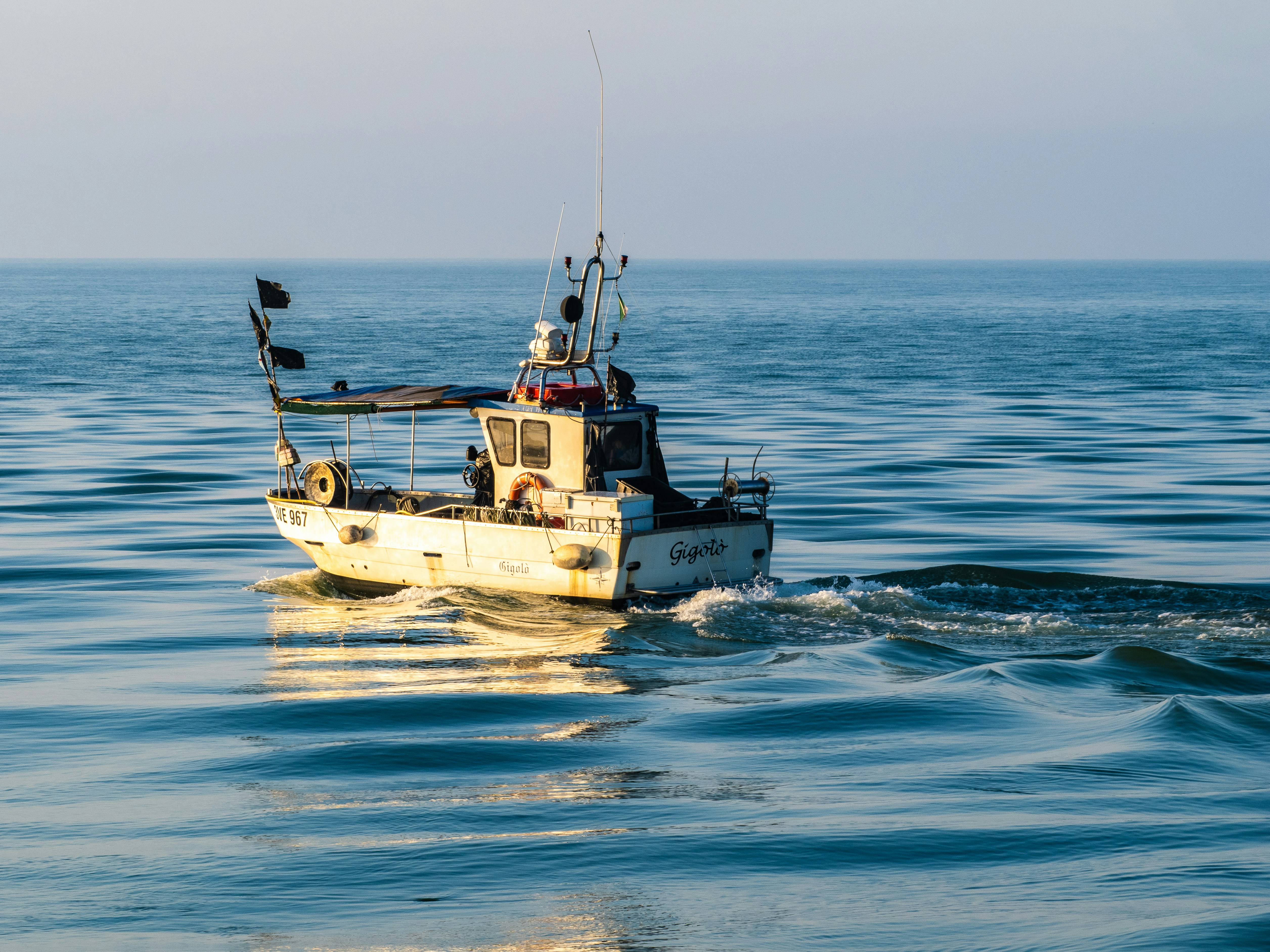 Boat Cutting Across Calm Seas at Golden Hour