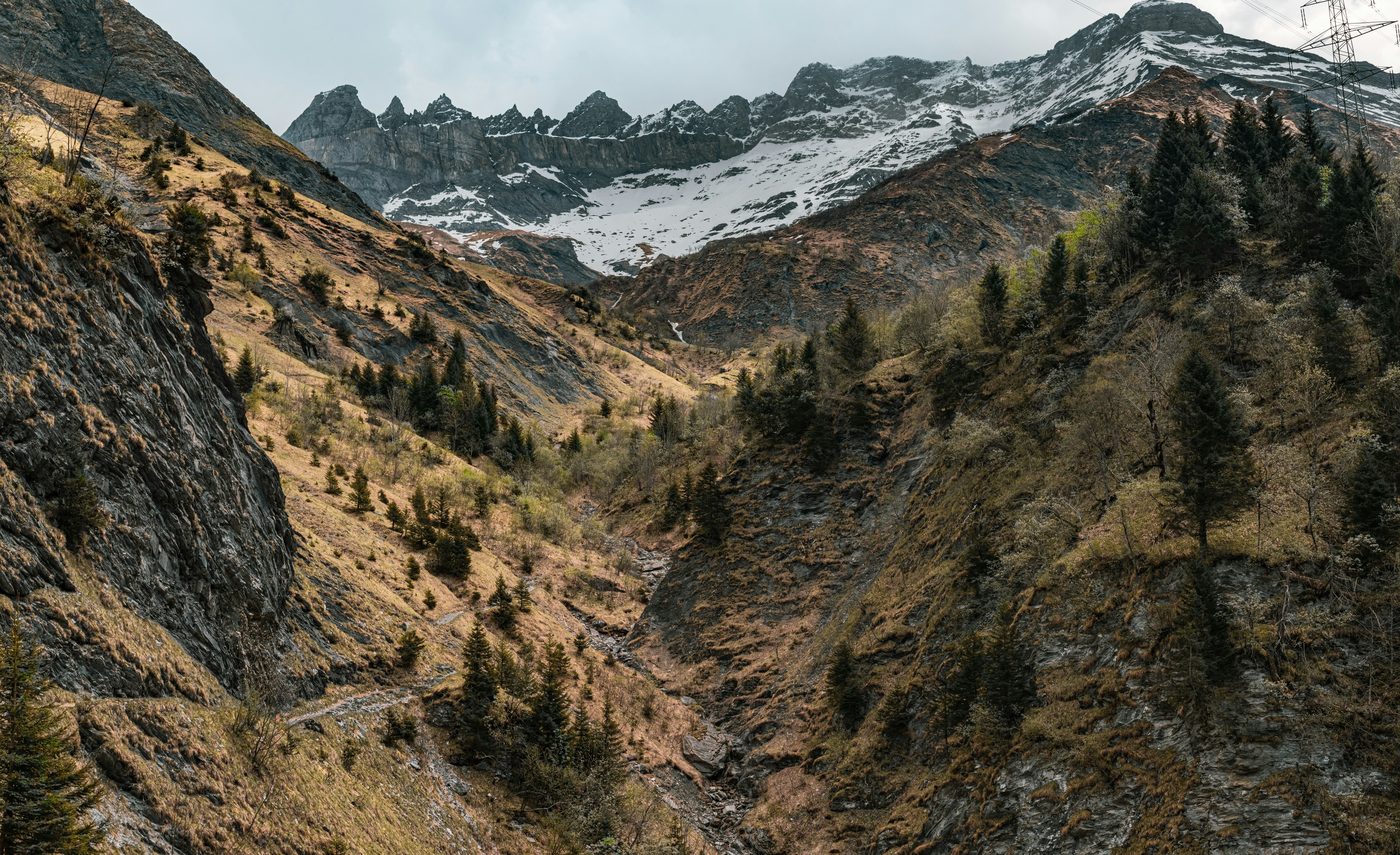 Hidden Alpine Gorge Beneath Snow-Capped Peaks