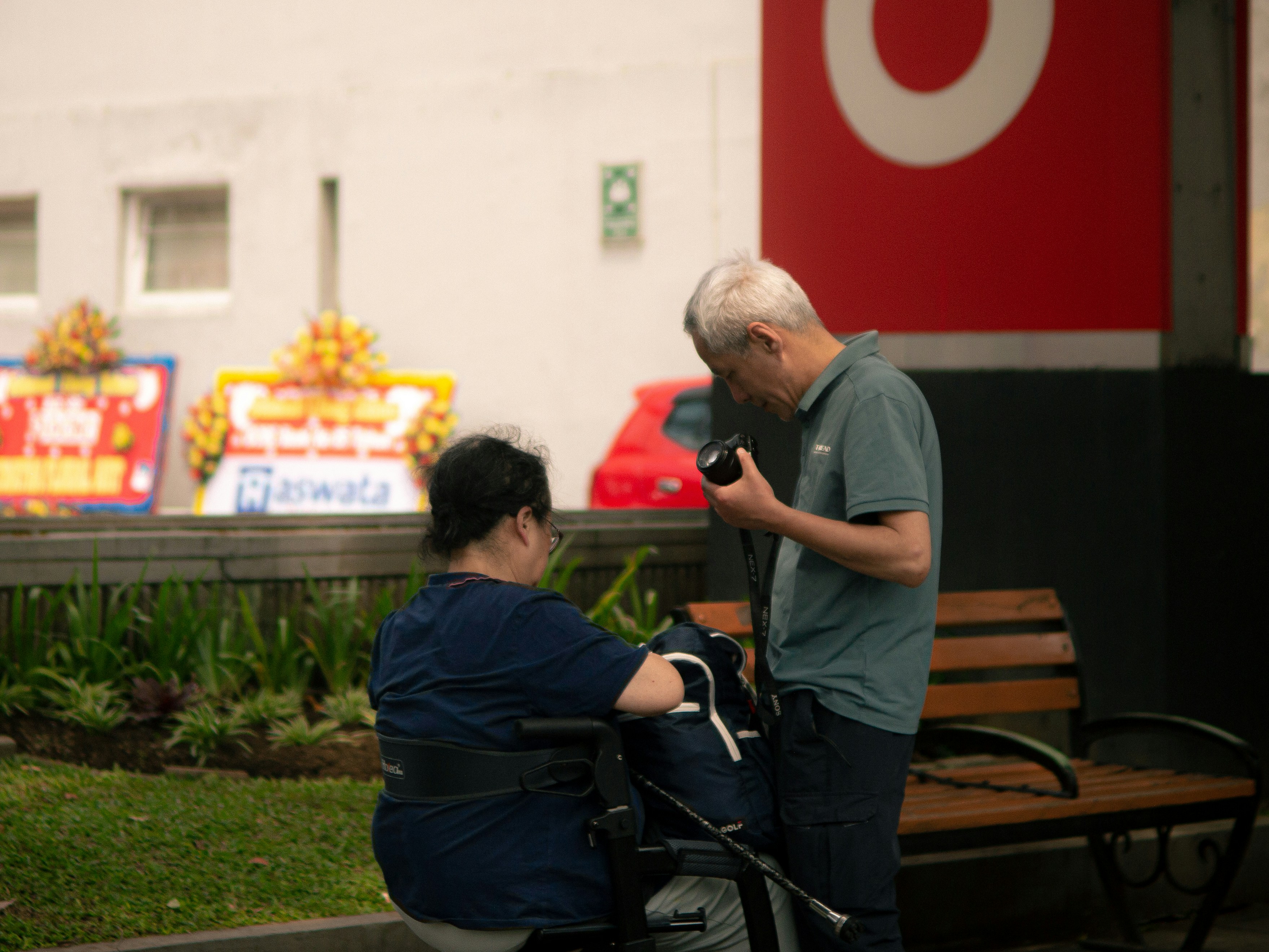 Quiet Exchange: A Caregiver and Photographer in a Shaded Park Bench Moment