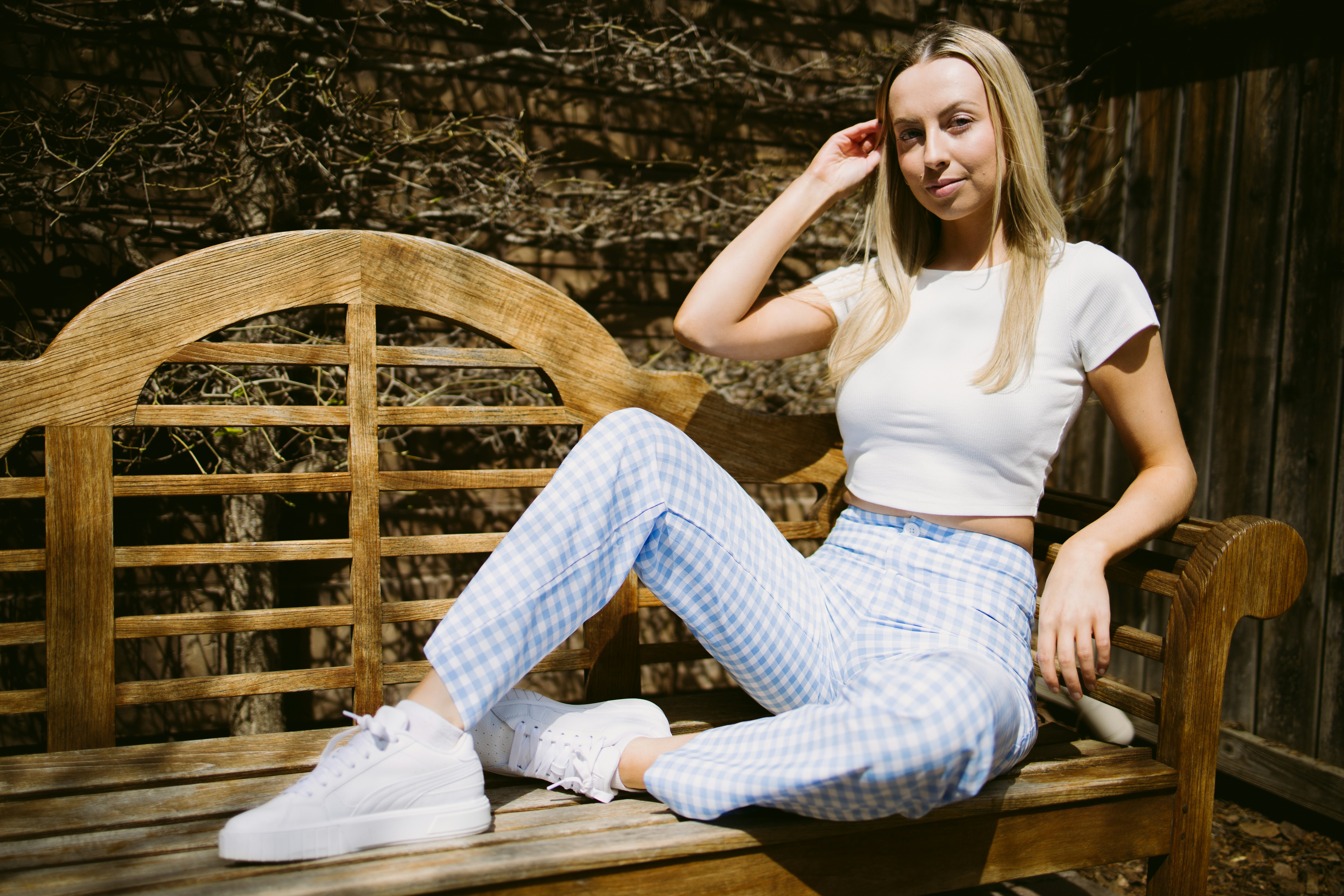 Sunlit Serenity: A Casual Portrait on a Wooden Bench
