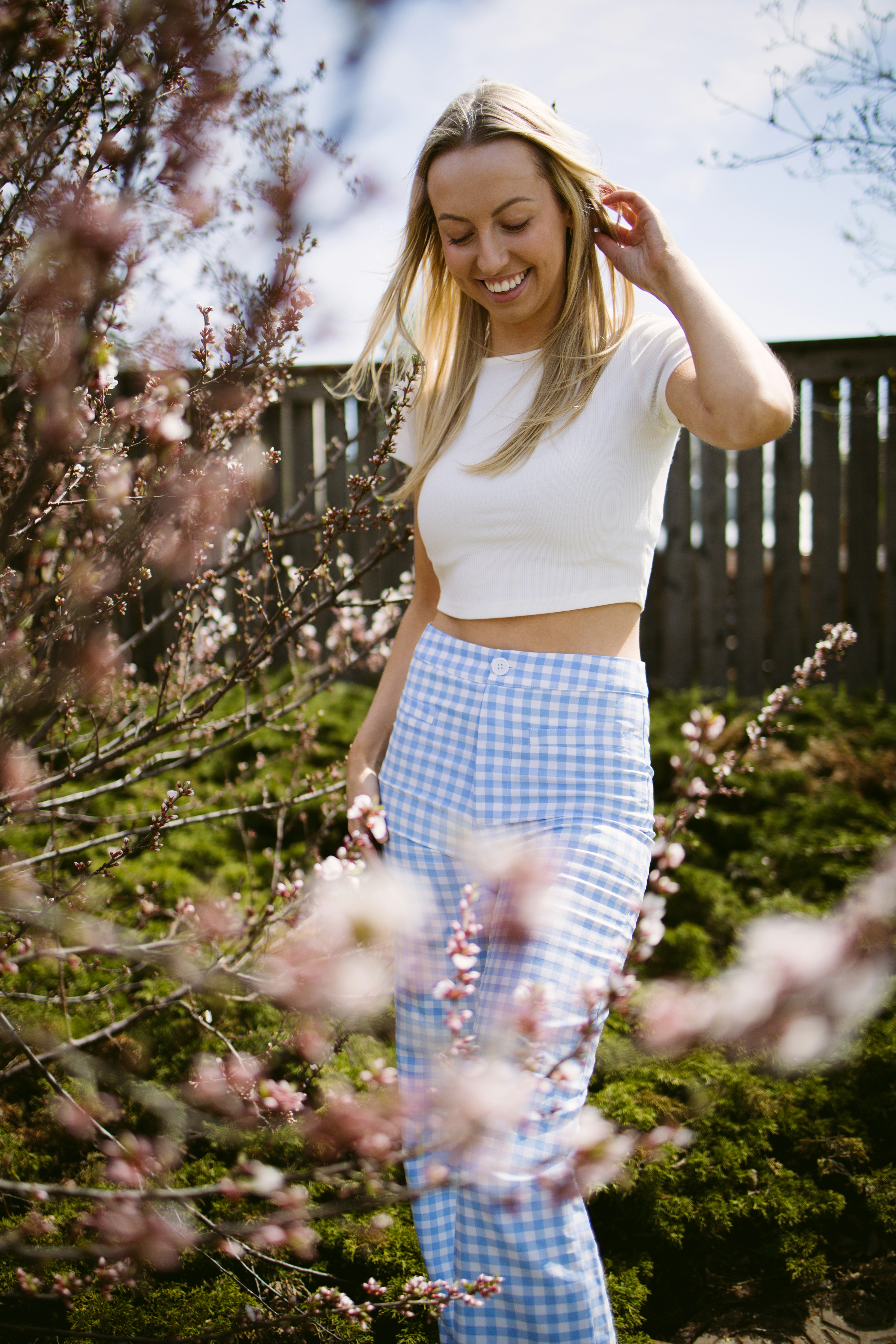 Spring Portrait: A Sunlit Smile Between Blossom Trails
