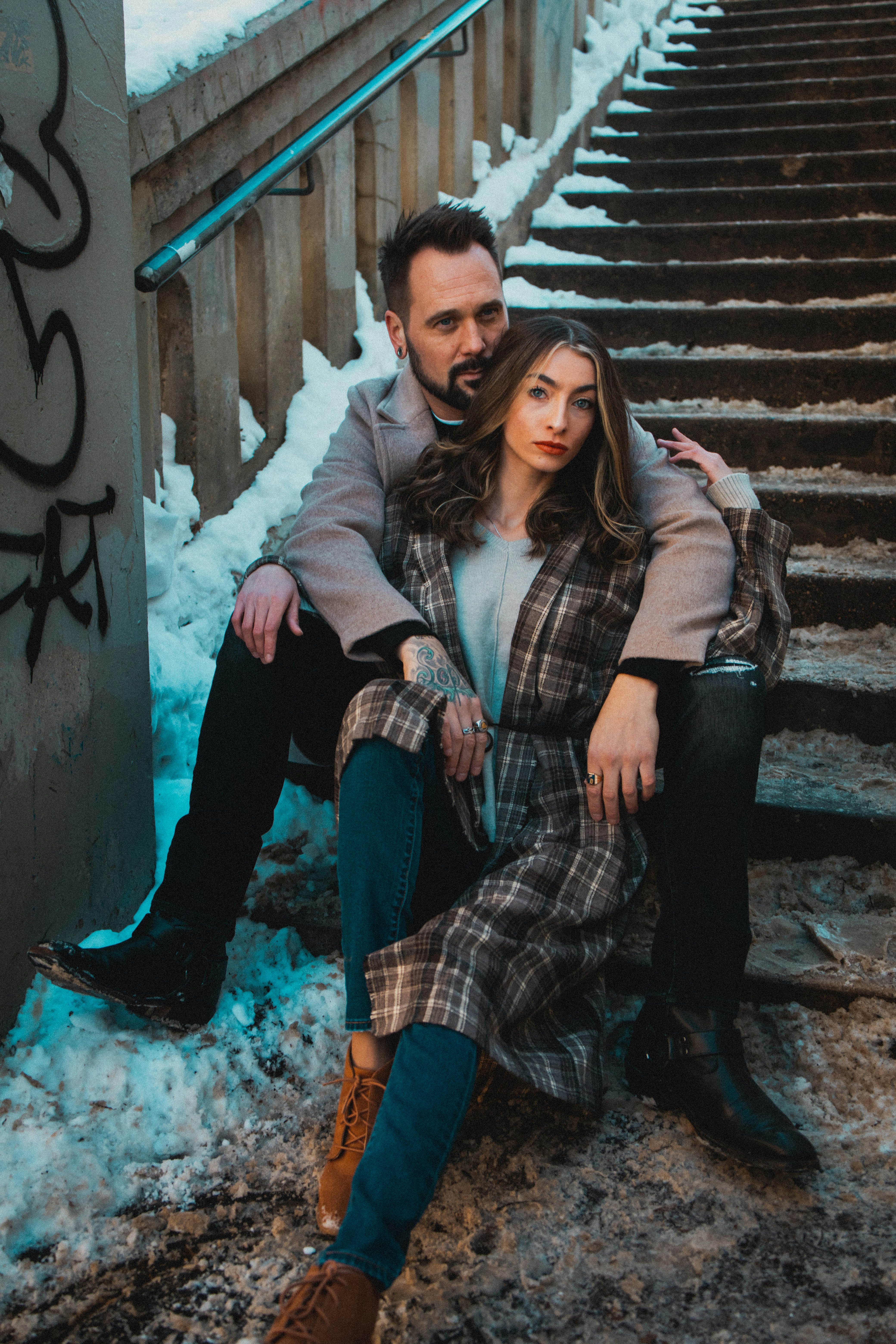 Urban warmth: a couple resting on snowy stairs