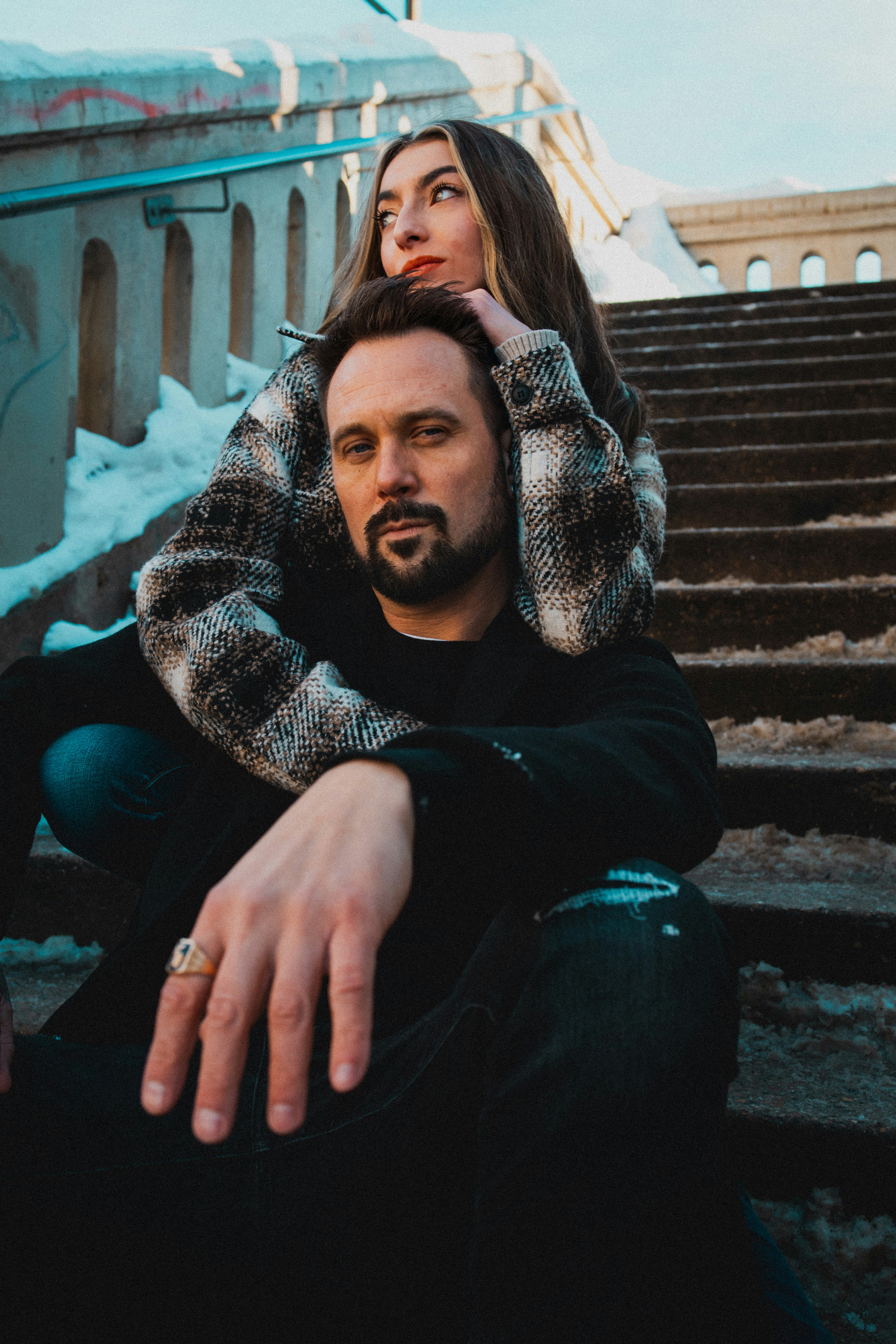 Couple sitting on outdoor stairs in winter