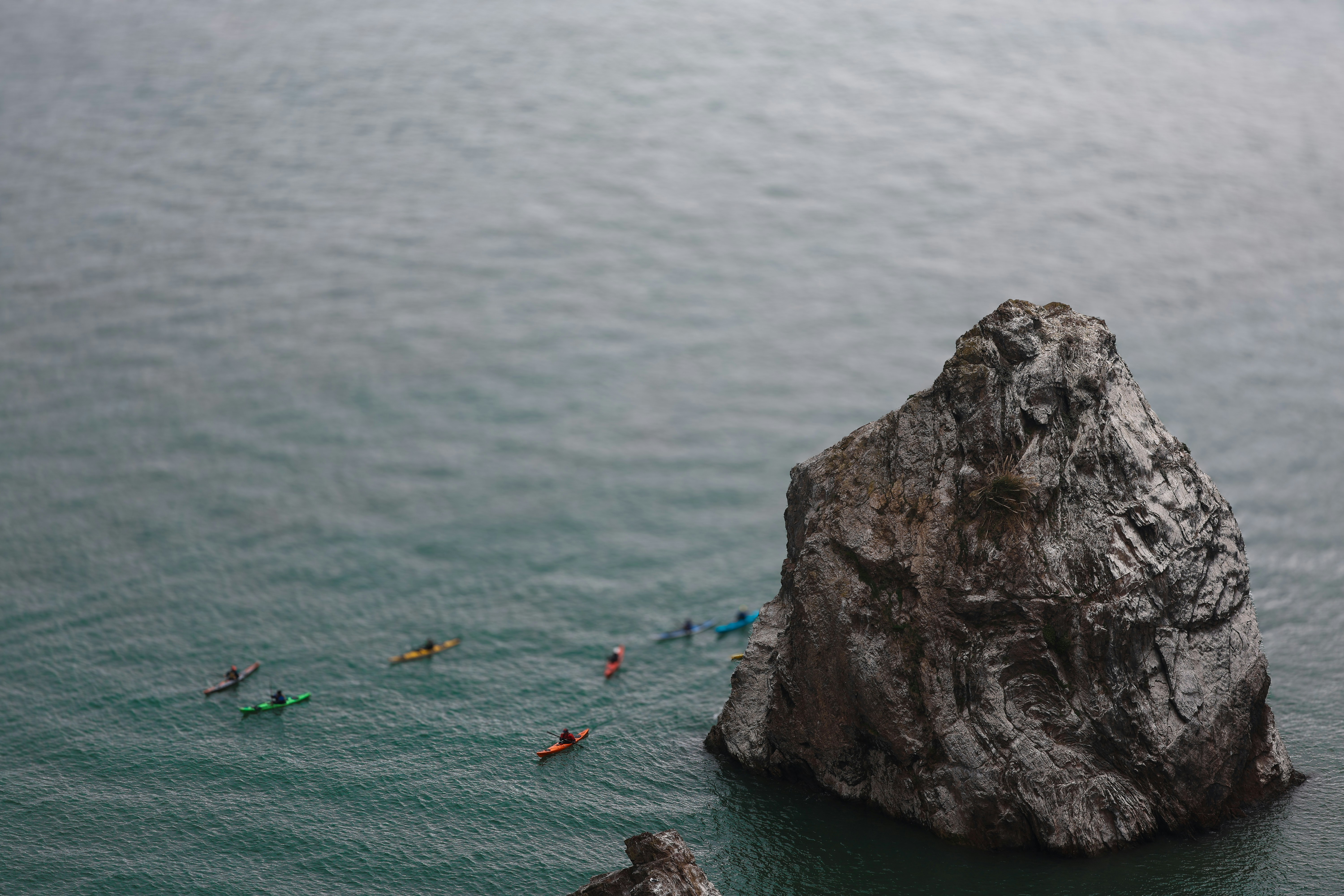 Sea Stance: A solitary rock and distant rowers