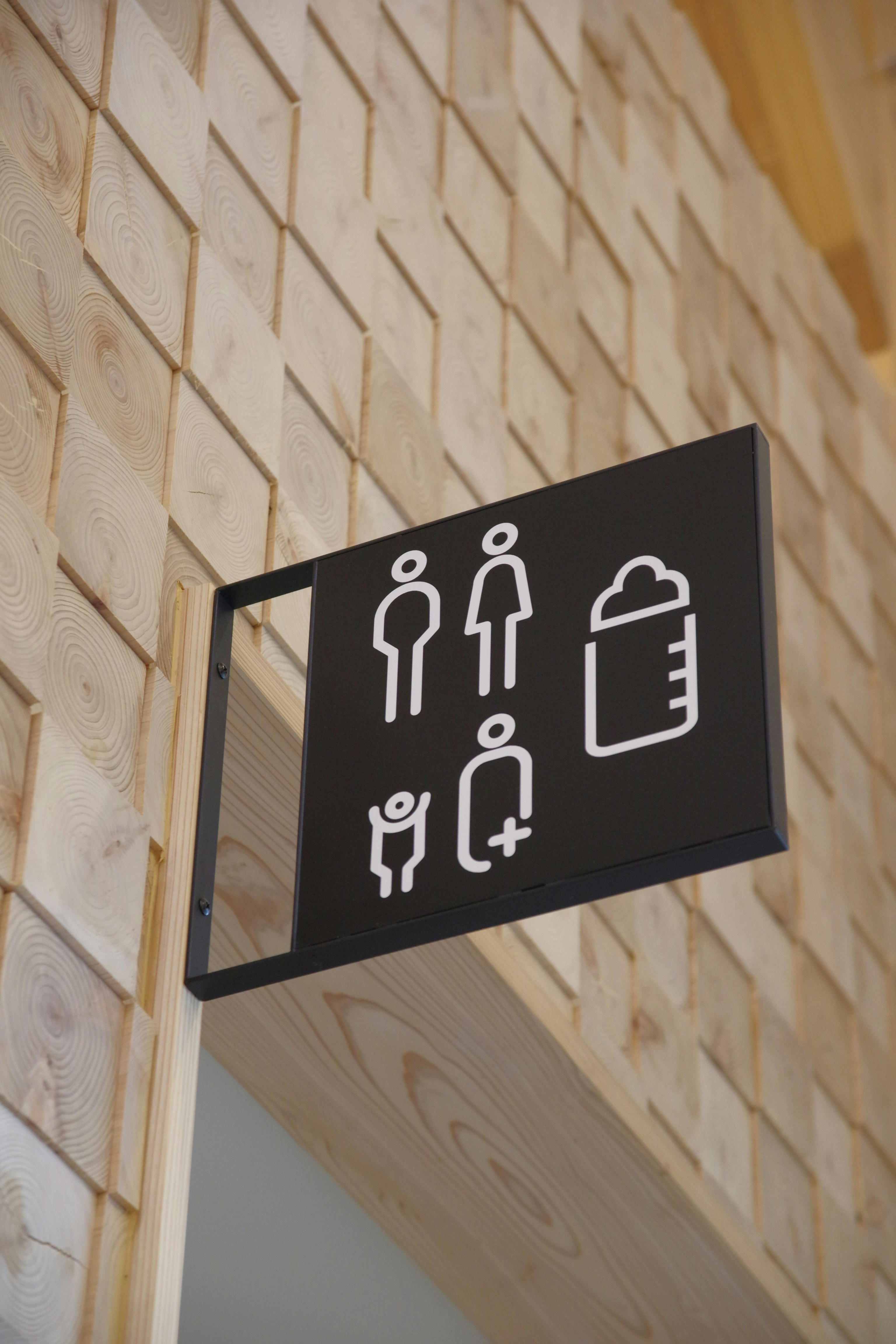 Signage in Wood-paneled Interior Shows Family Accessibility Icon