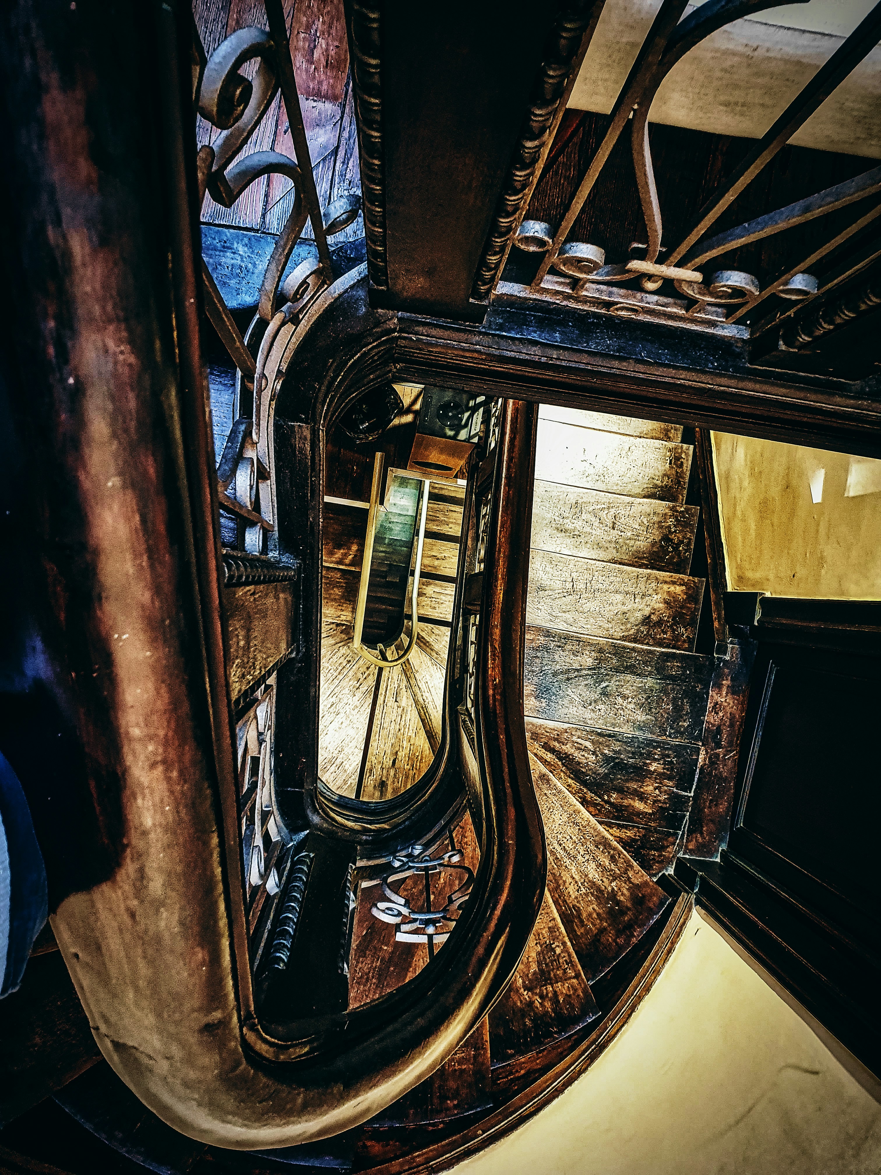 A labyrinth of stairs: spiraling iron and wood in a vintage stairwell