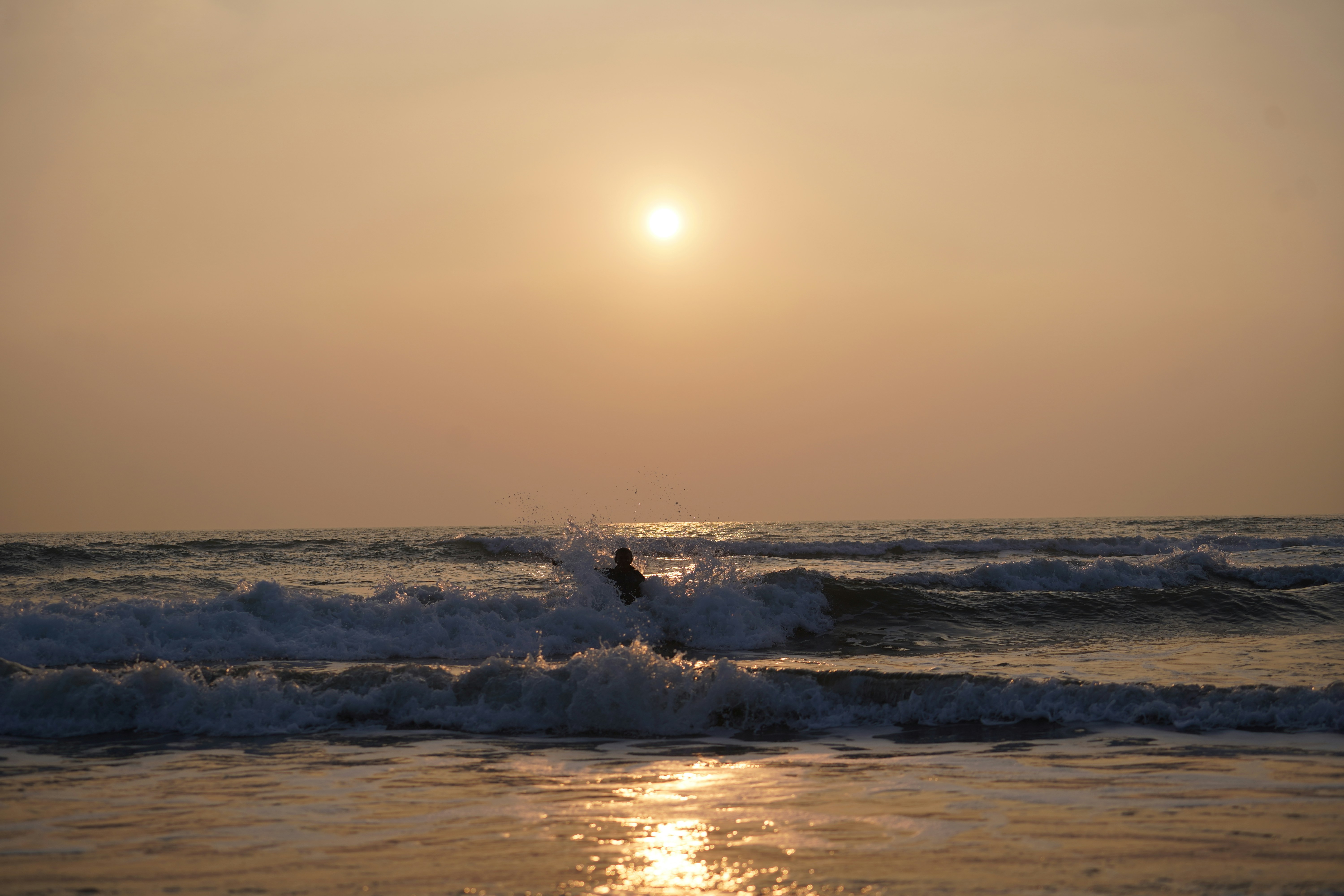 Sunset Rider: A lone surfer in the glowing sea