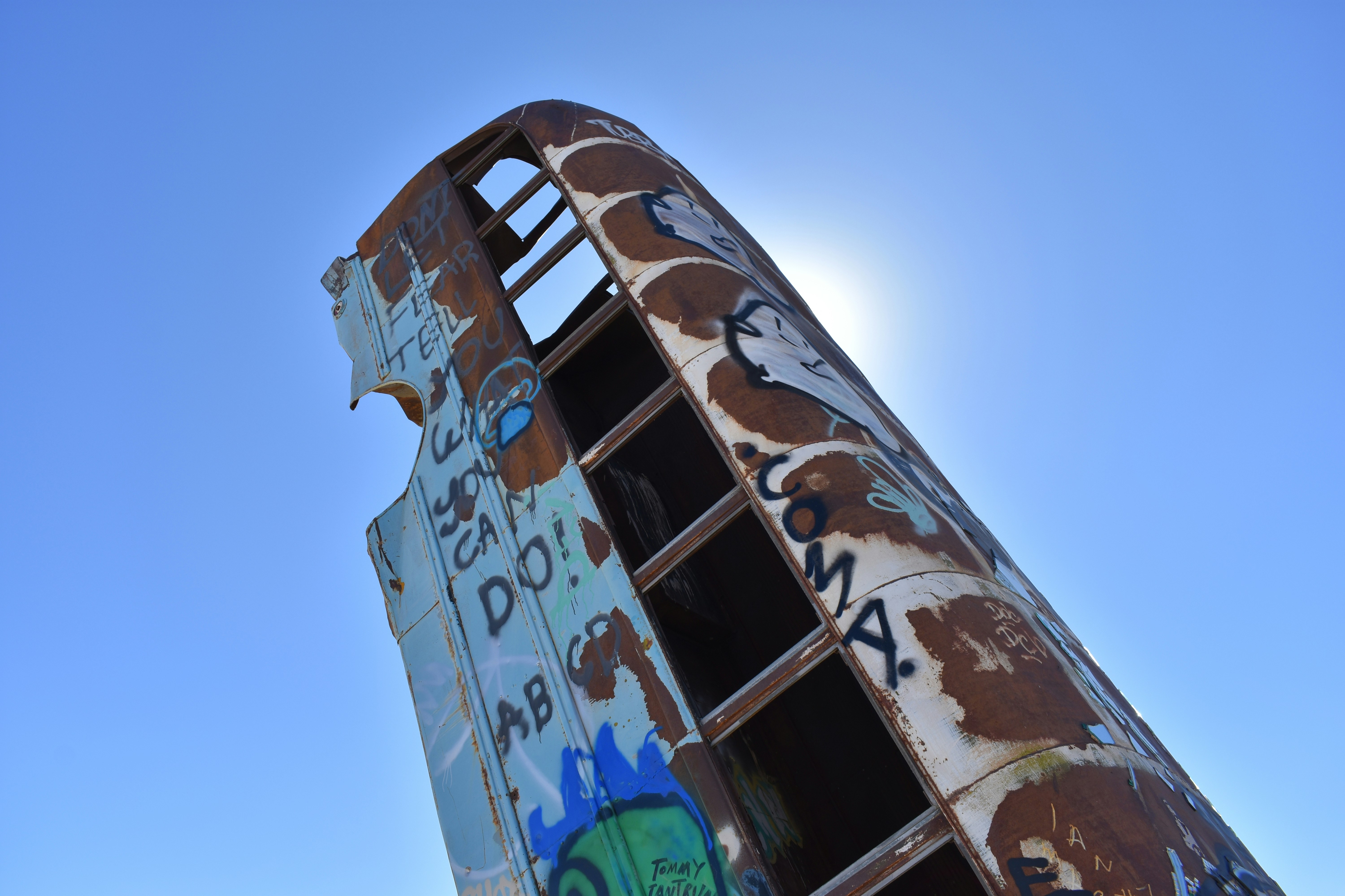 Rusted sculpture rises against a clear blue sky