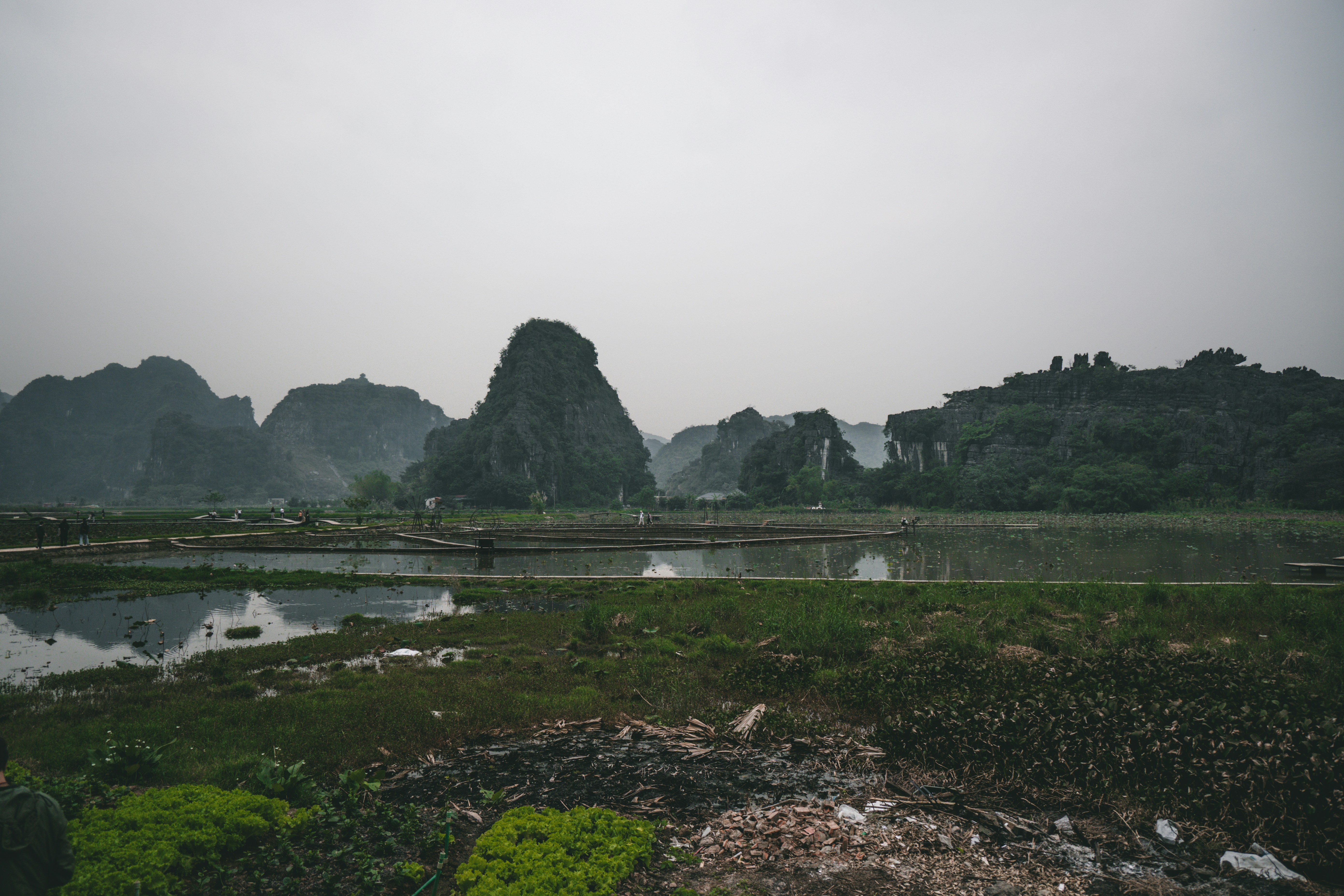 Misty karst mountains rise over a tranquil lake.