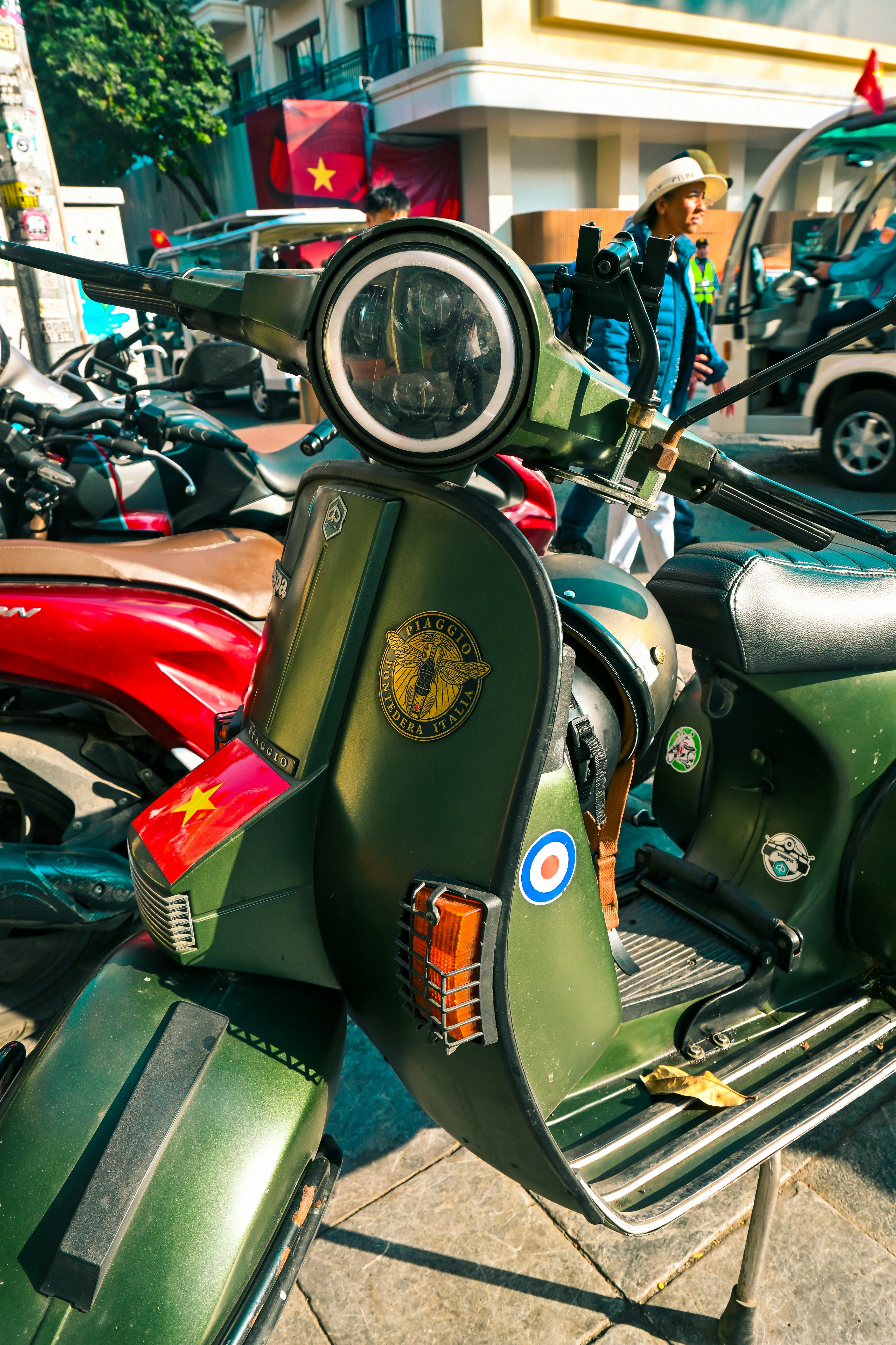 Military Green Vespa in a Bustling Street Scene