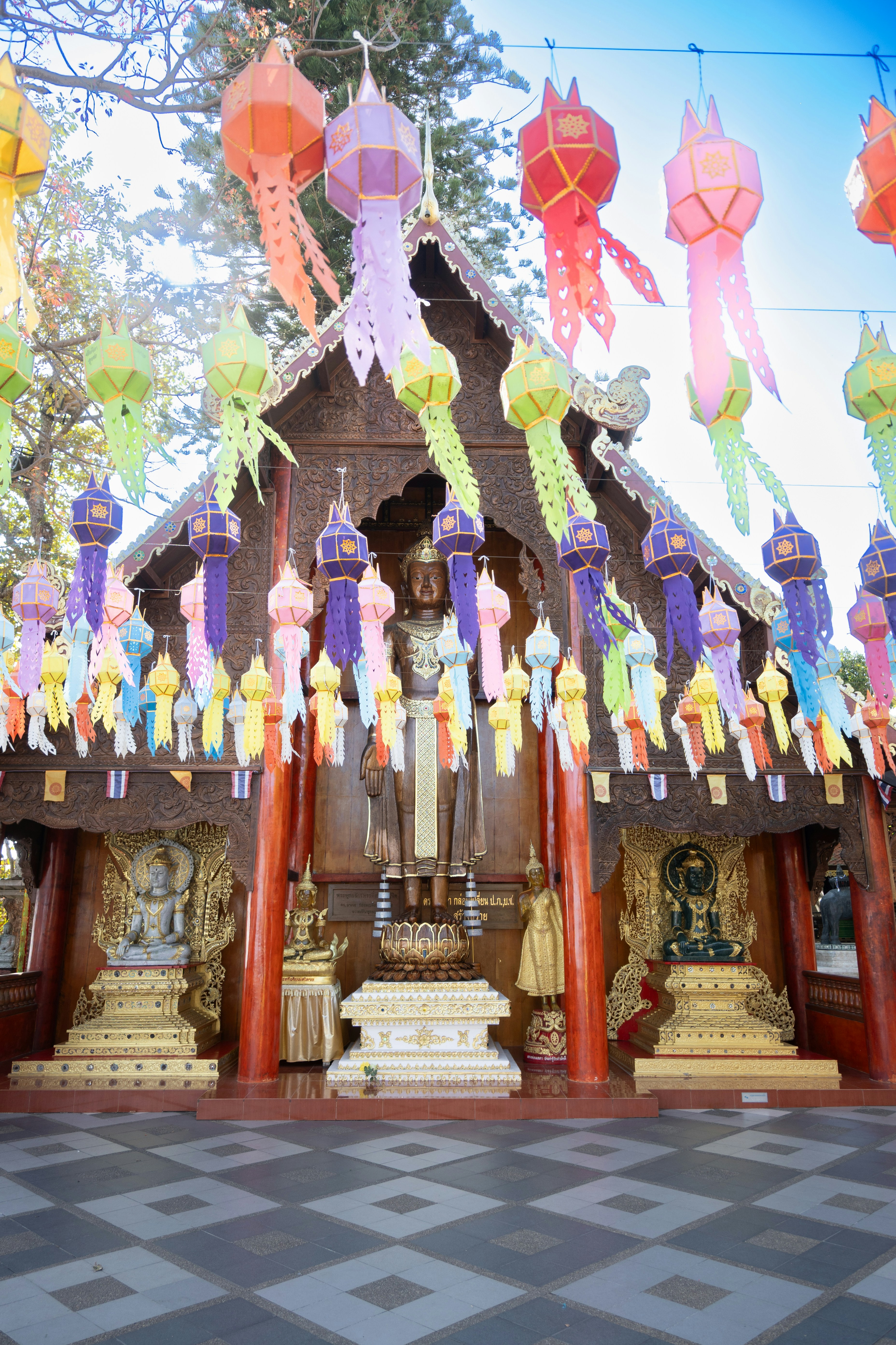 Colorful Lanterns Crown a Shrine: A Meditative Scene of Decor and Statues