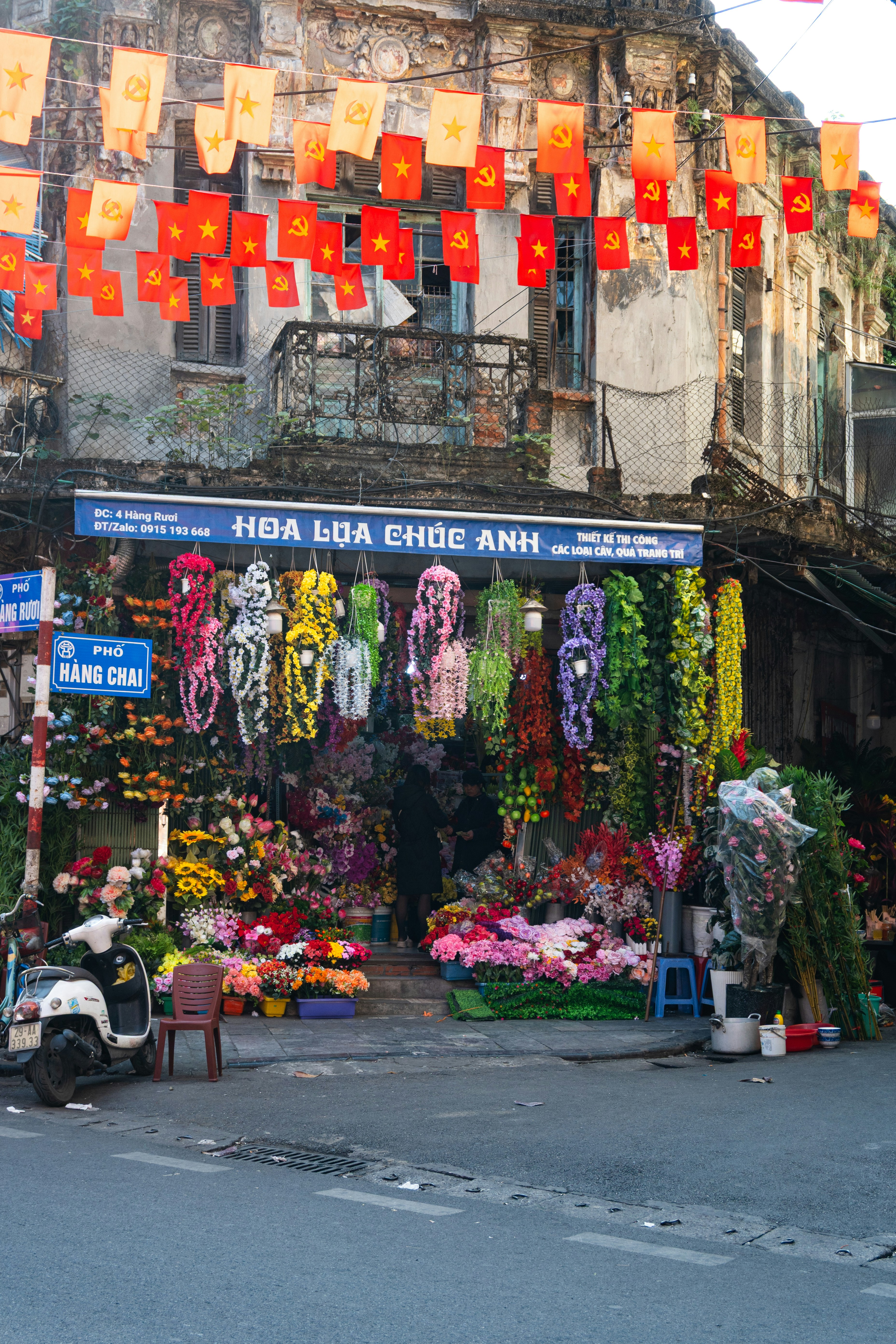 Flower Shop Under a Parade of Flags in a Busy Vietnamese Street
