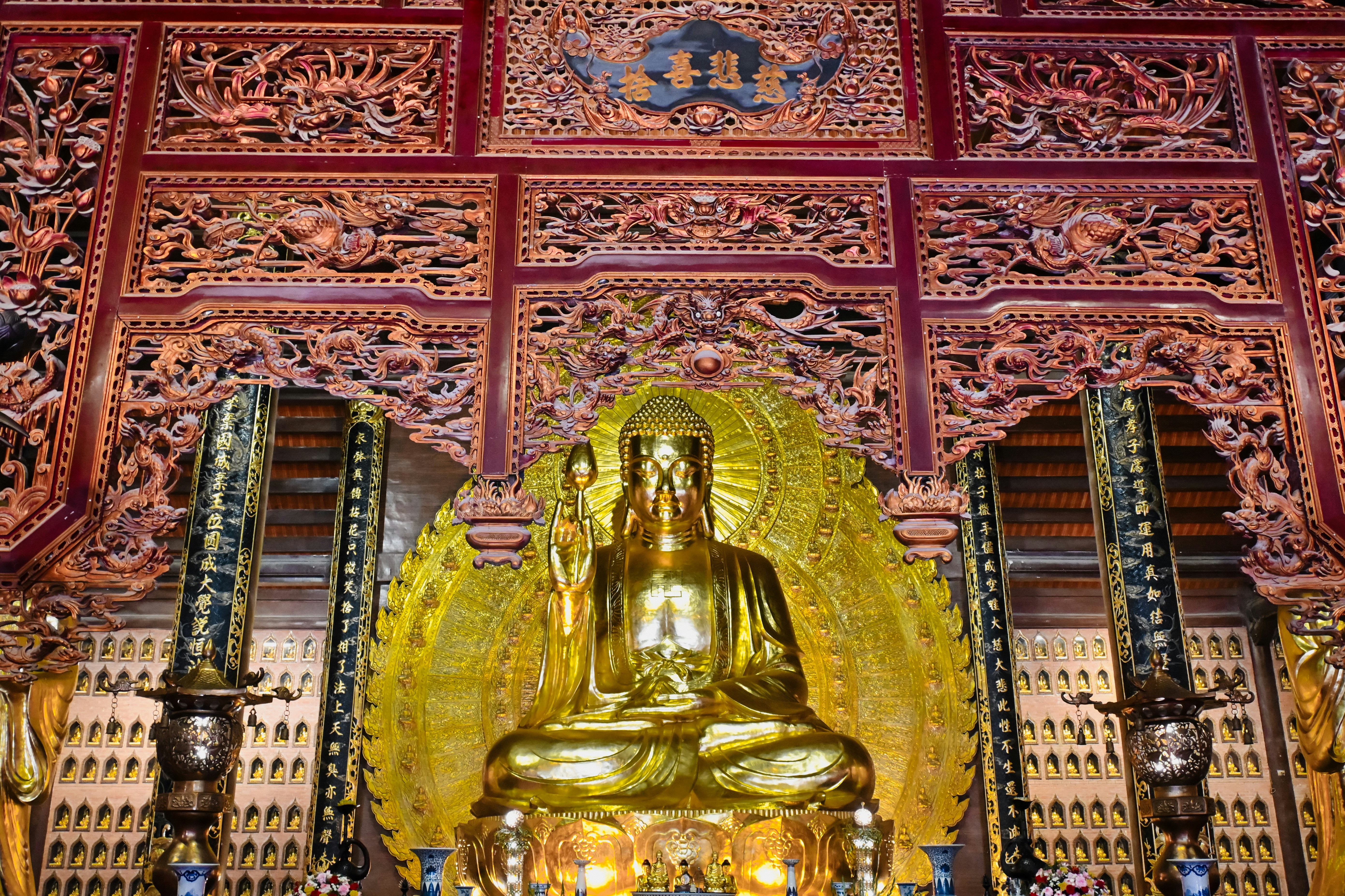 Golden Buddha Amid Ornate Carvings in a Shrine