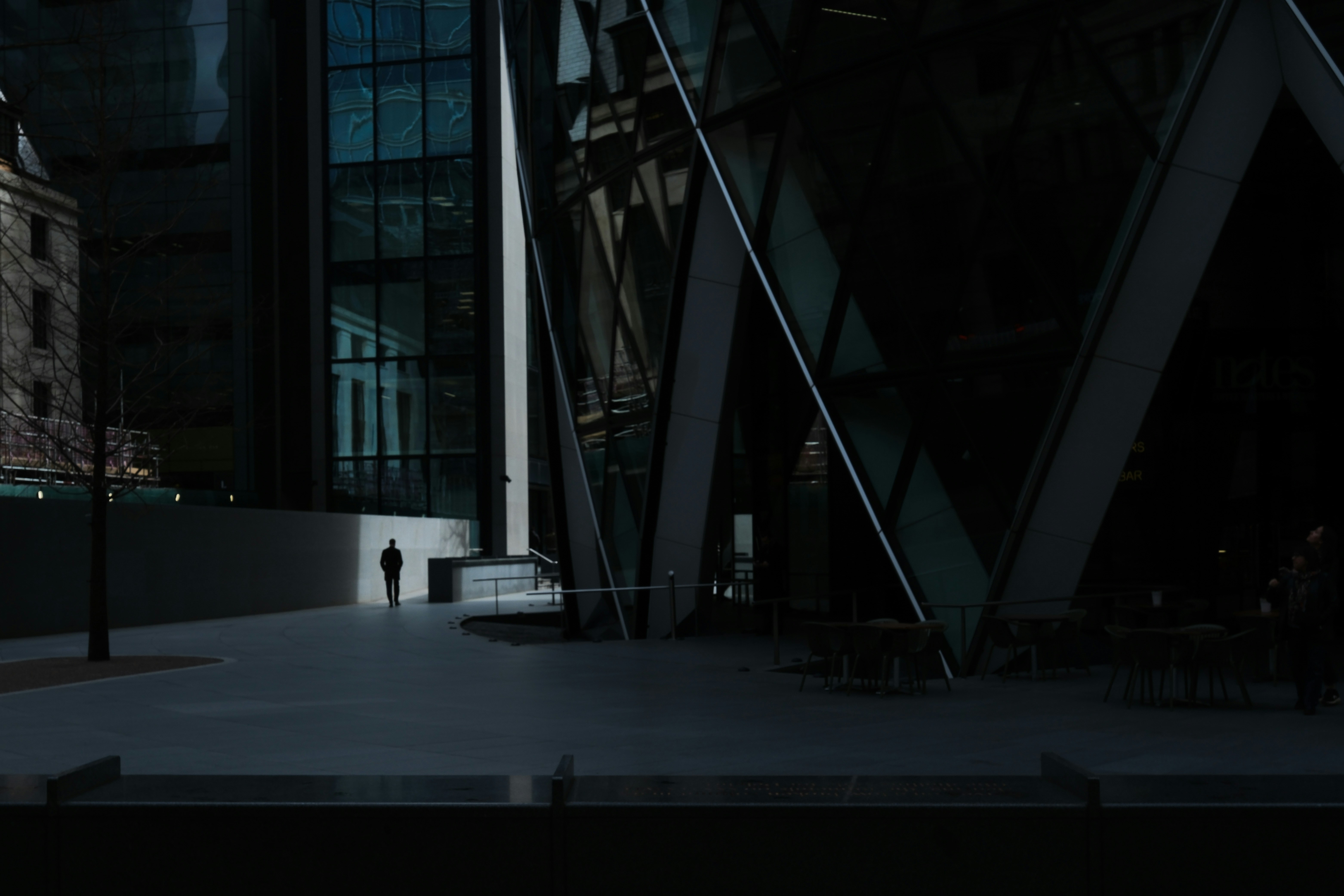 Silhouette at the Edge of Light: A Quiet Step Toward the Glass Facade