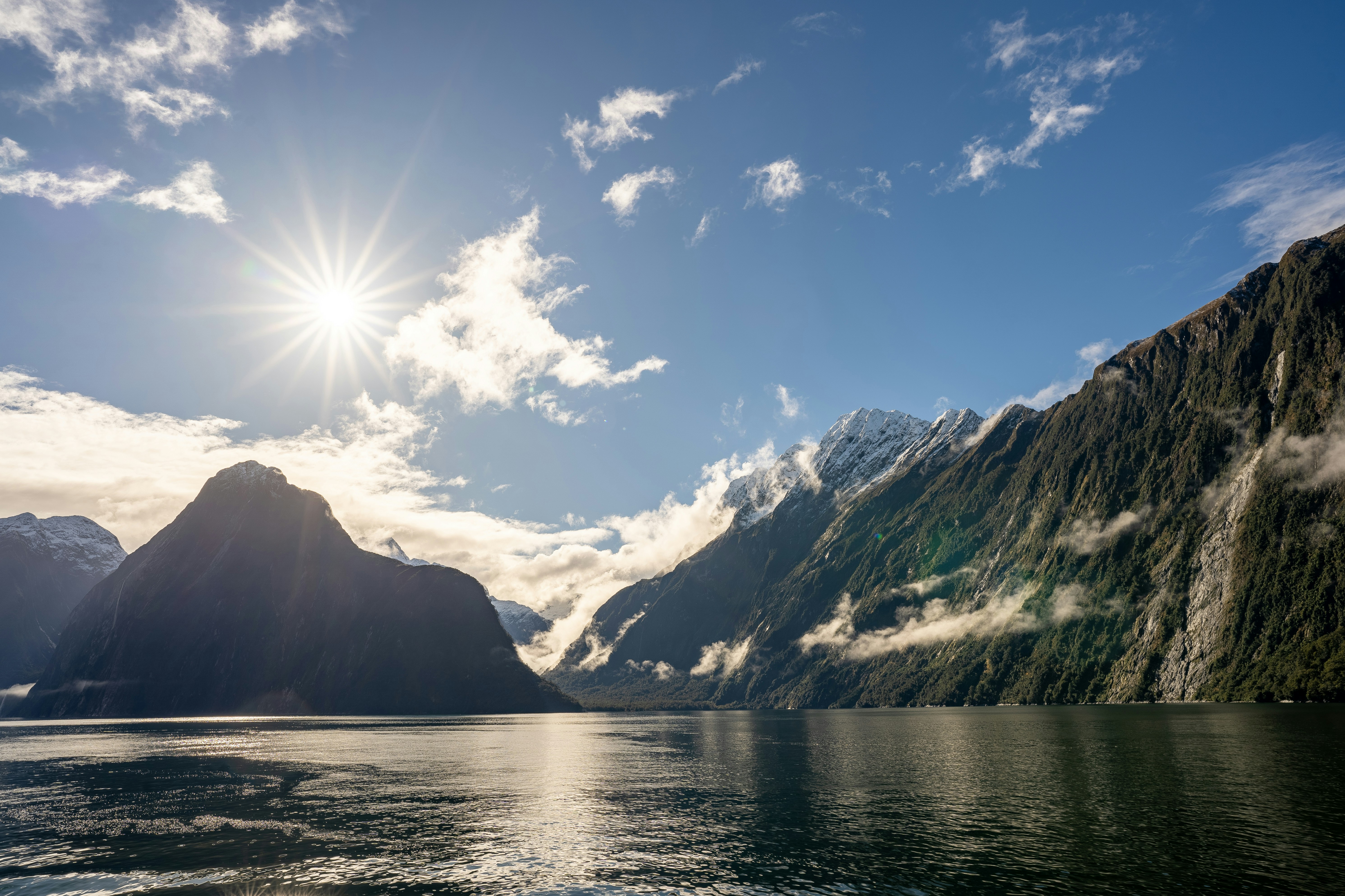 Sunlit Fjord Symphony Against Towering Peaks