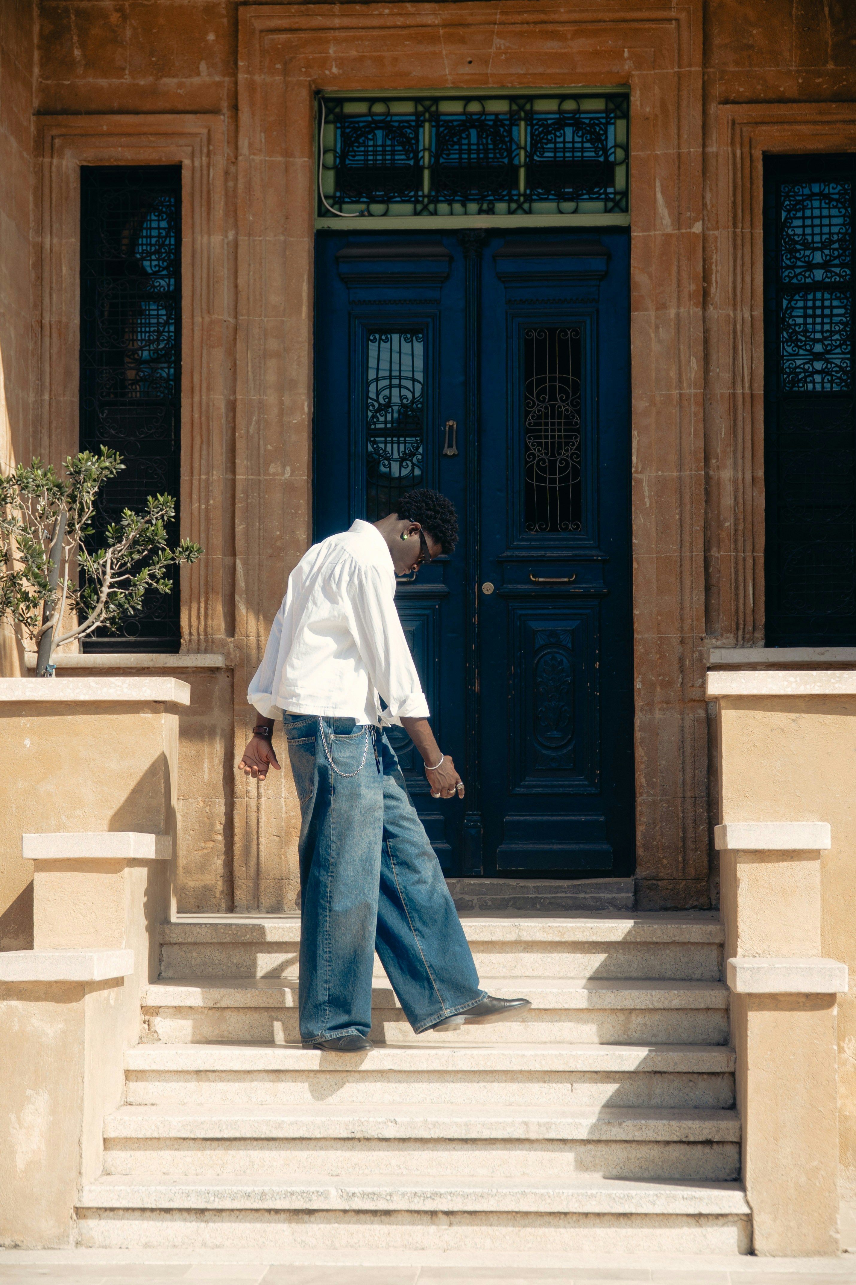 Stride in the Shade: Portrait on the Blue Door Threshold