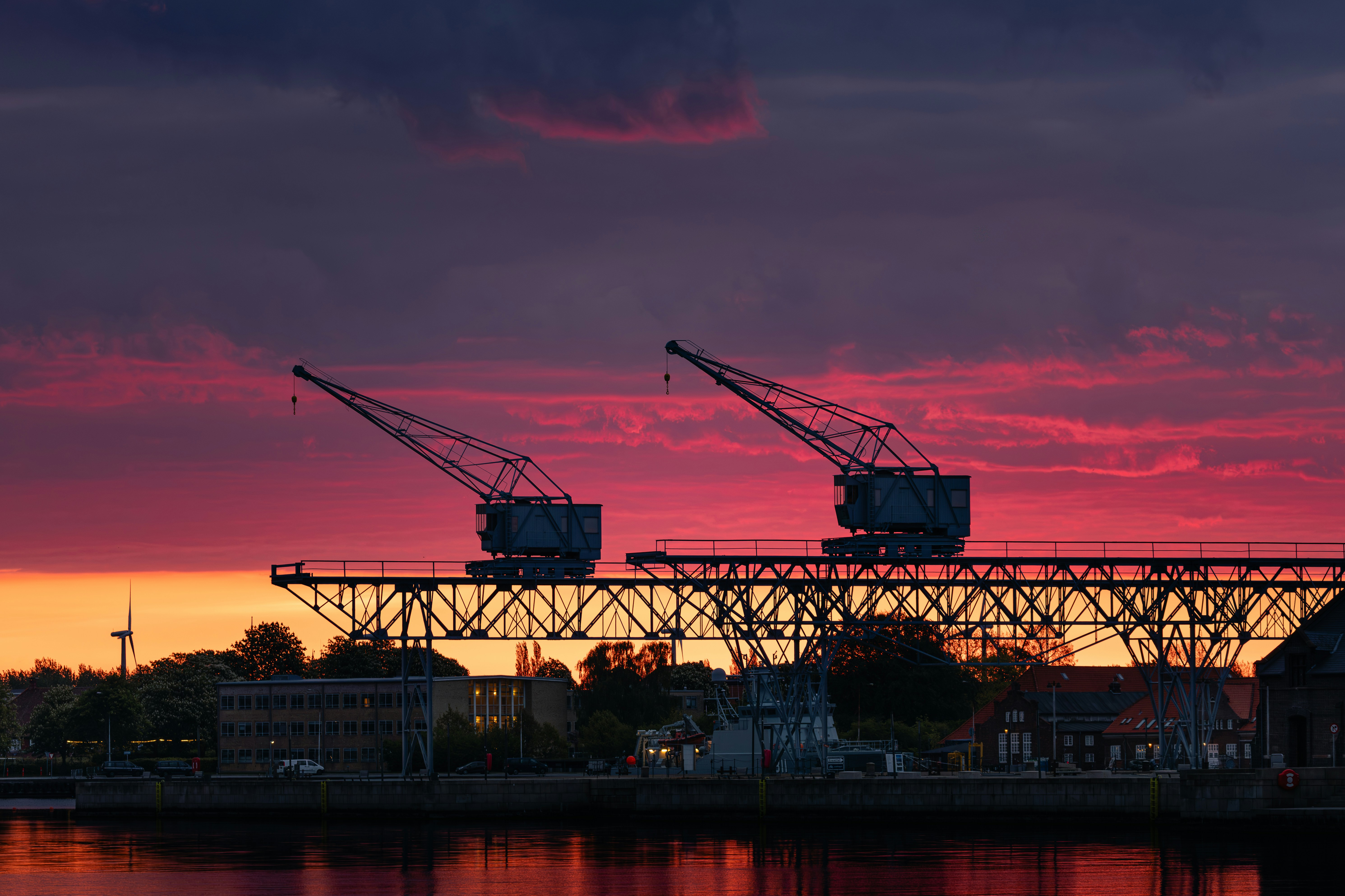 Crane silhouettes at sunset over a calm river