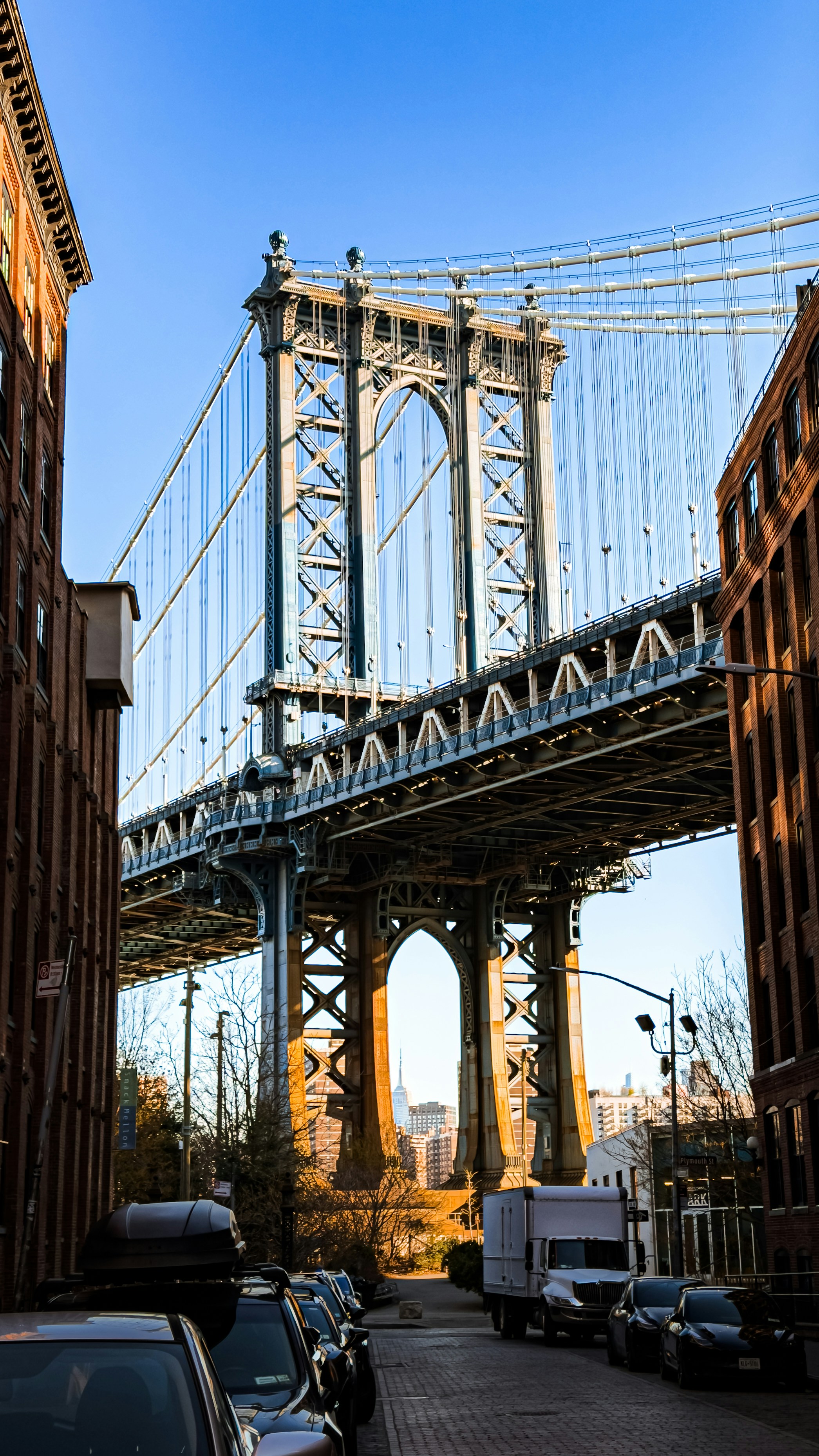 Steel Giants Over Cobblestones: The Manhattan Bridge Framed by Brick Towers