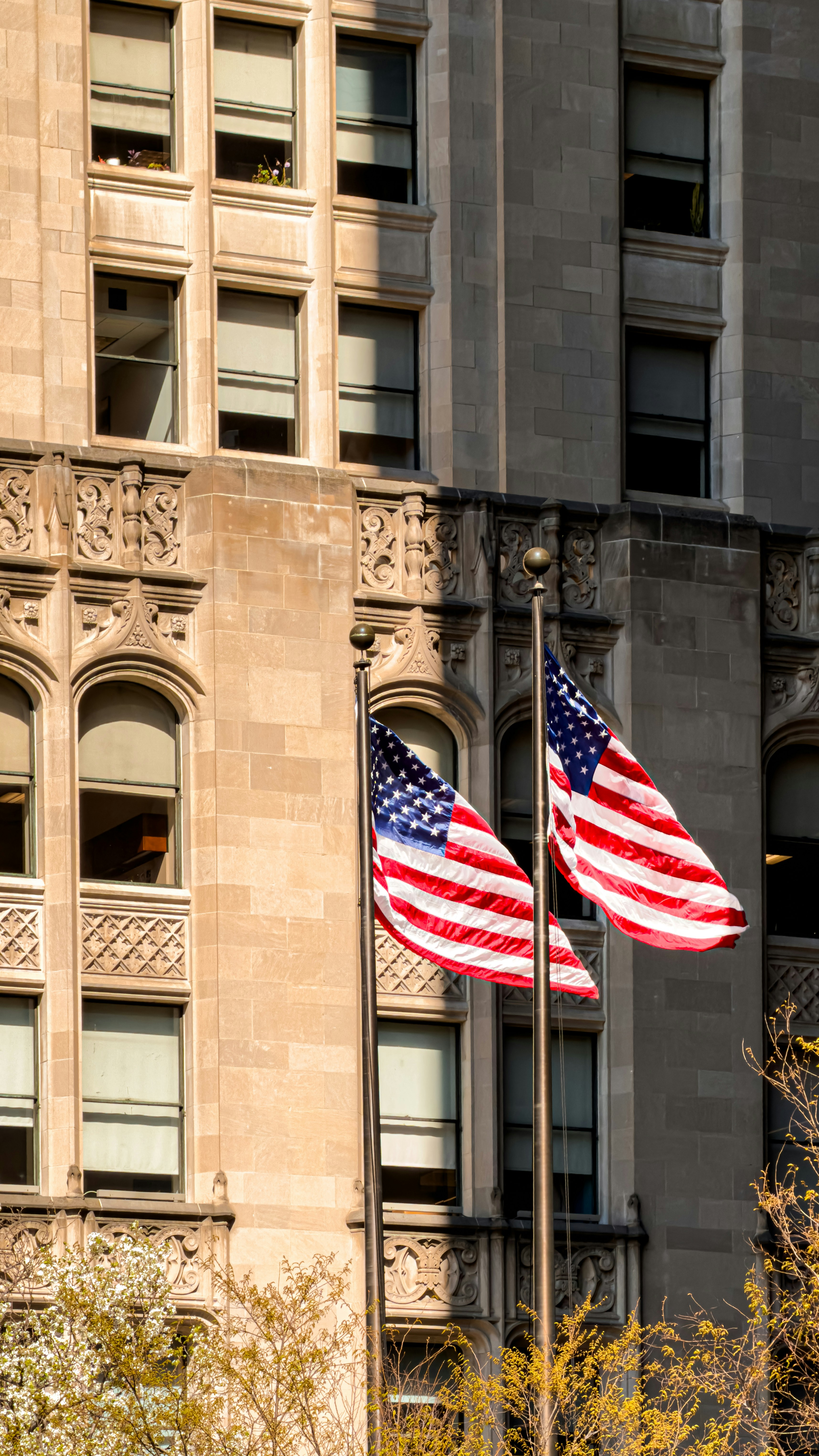 American Flags Against ornate urban façade